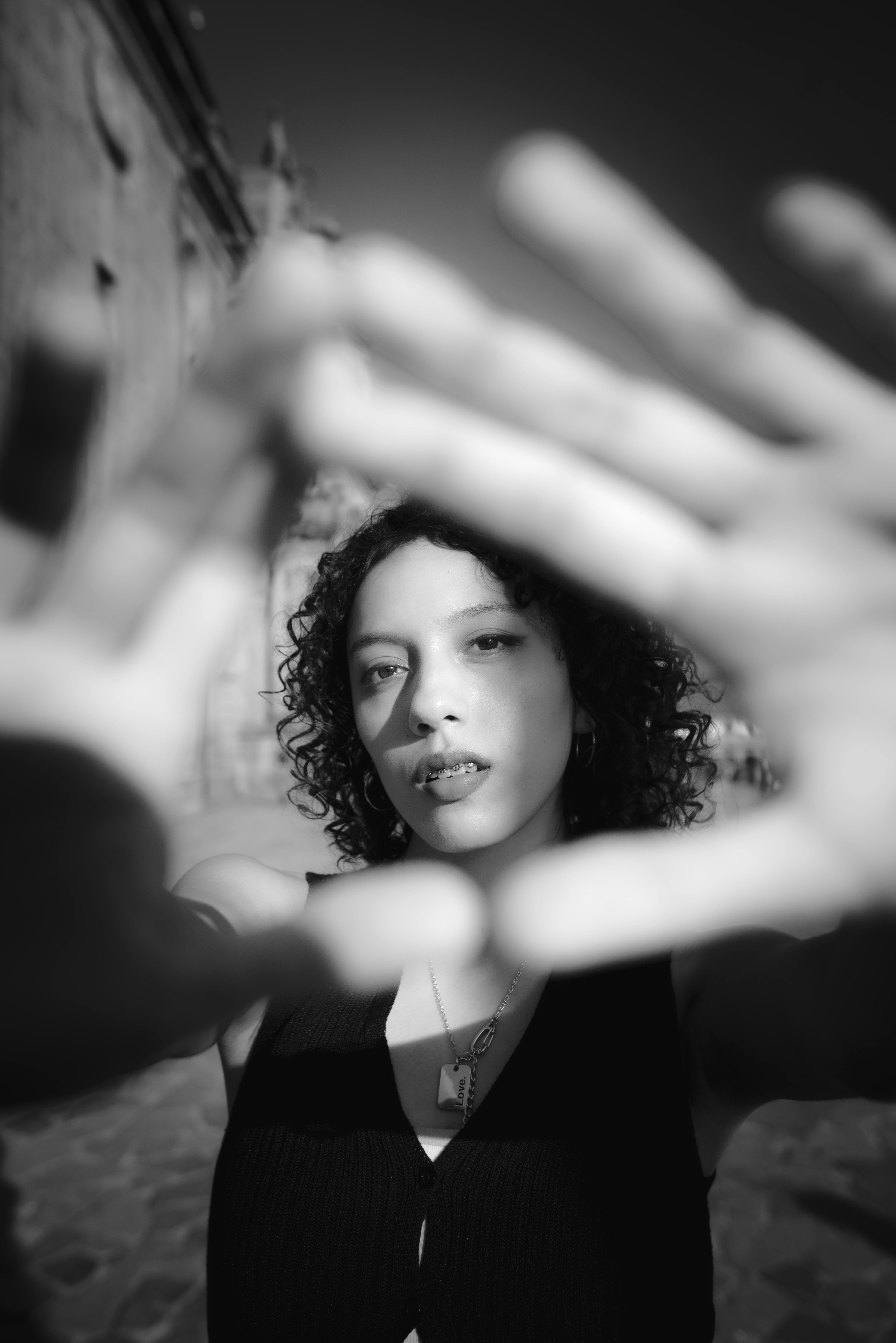 Woman Portrait behind Hands in Black and White · Free Stock Photo