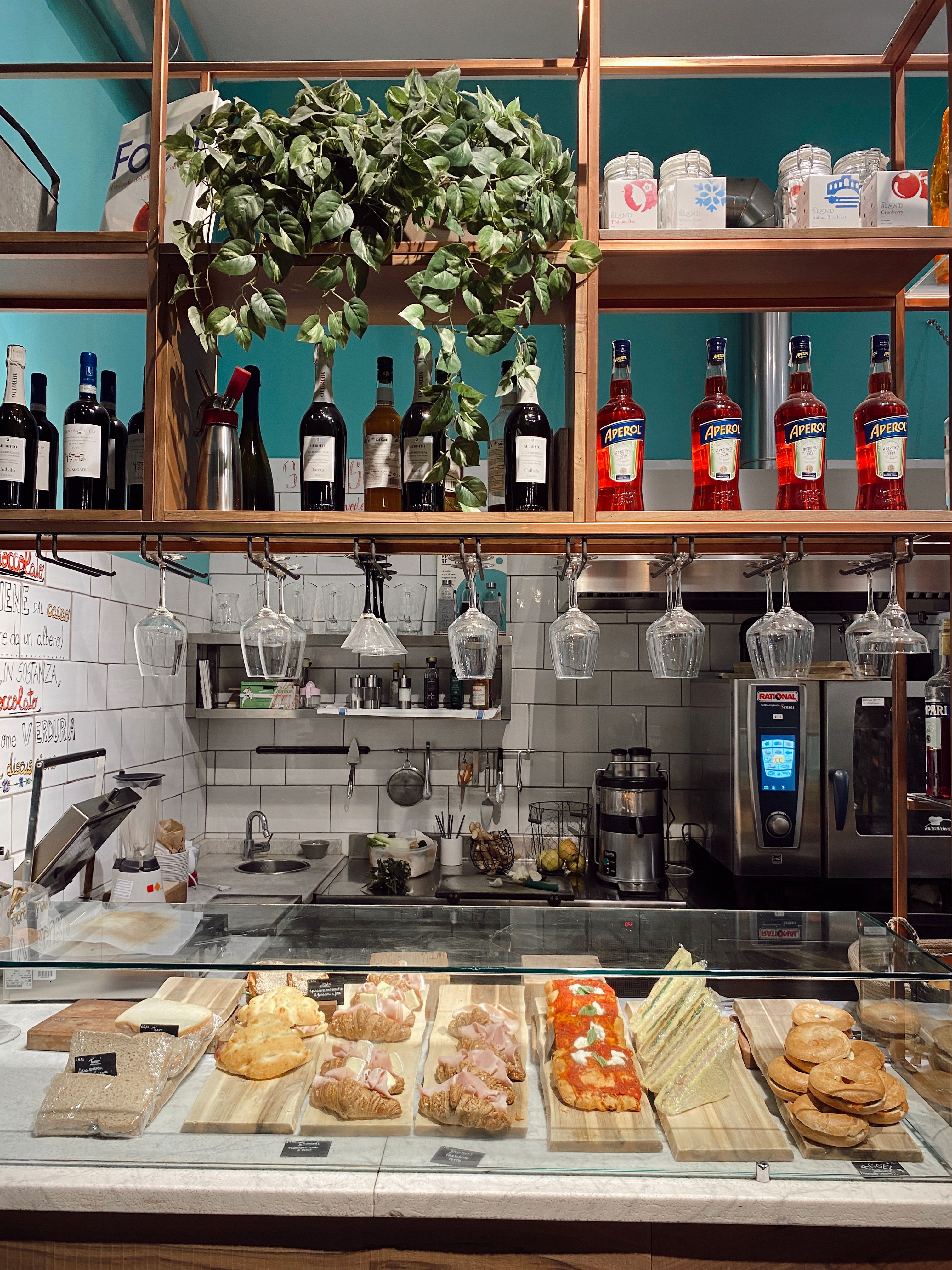 Wine Bottles on Shelves over Counter in Food Bar · Free Stock Photo