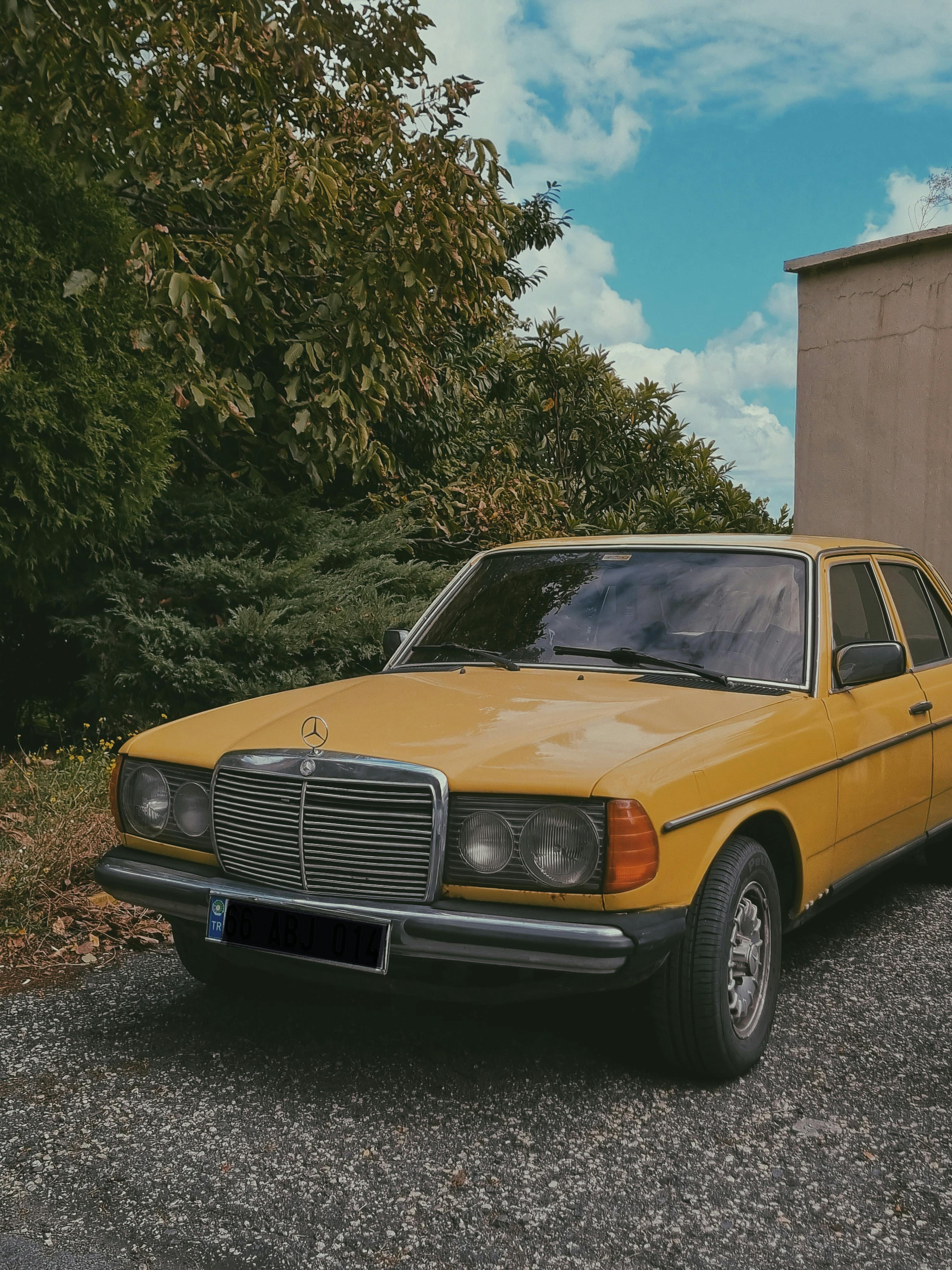 A Yellow Mercedes-Benz W123 Parked near Tree · Free Stock Photo