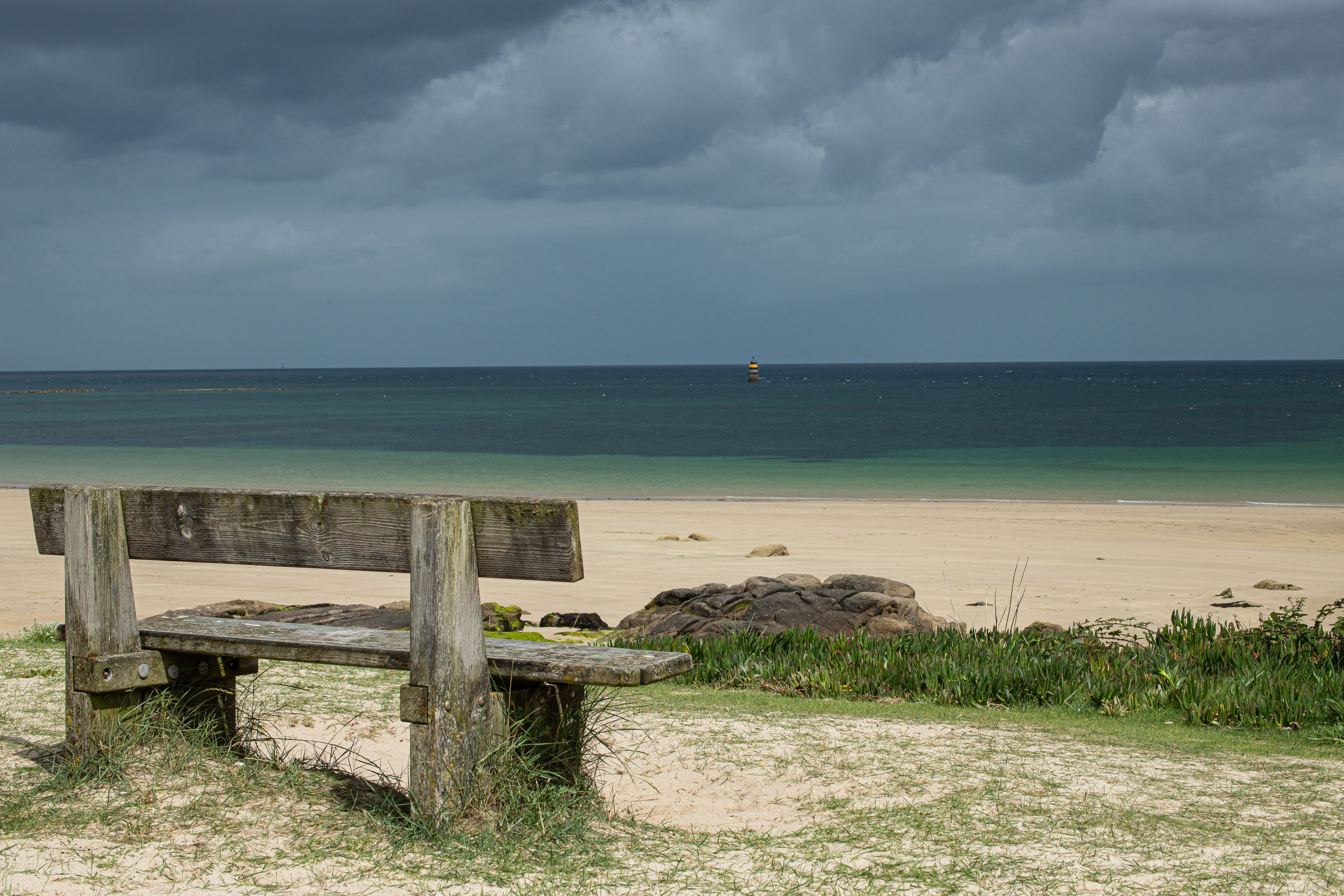 An Empty Wooden Bench Standing on a Beach under a Cloudy Sky · Free ...