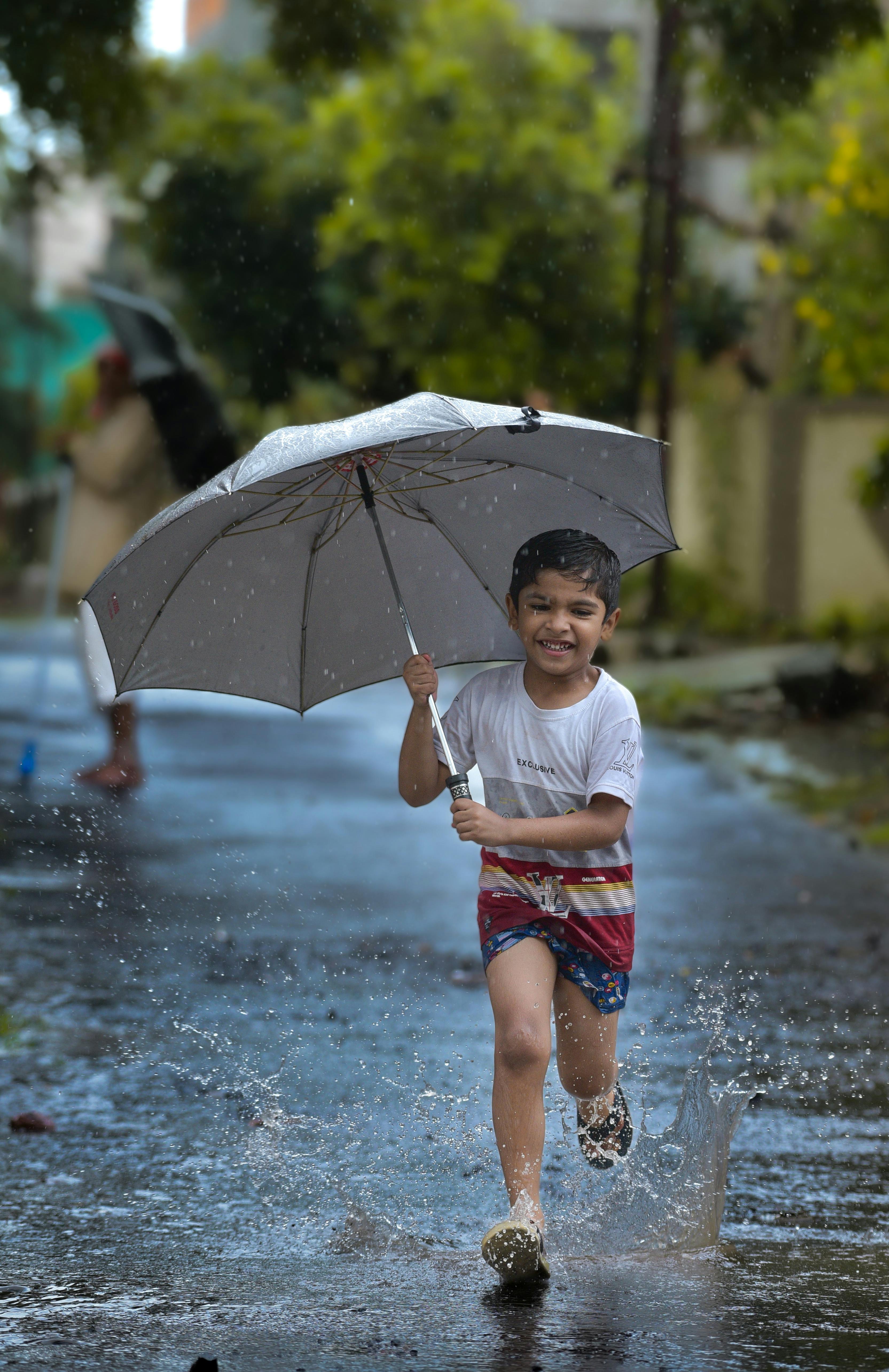 Boy with Umbrella Running on Street in Rain · Free Stock Photo