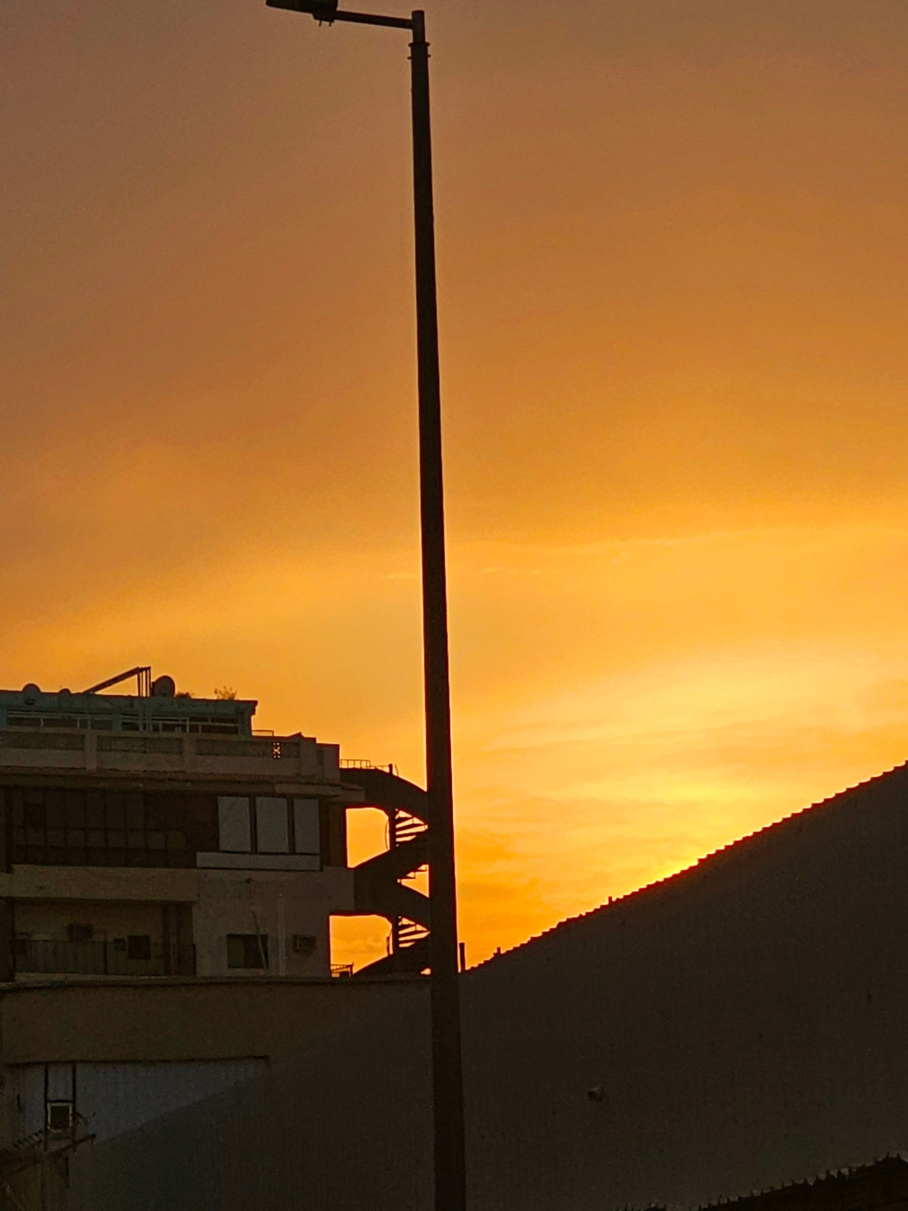 Yellow Sky over Street Lamp and Building at Sunset · Free Stock Photo