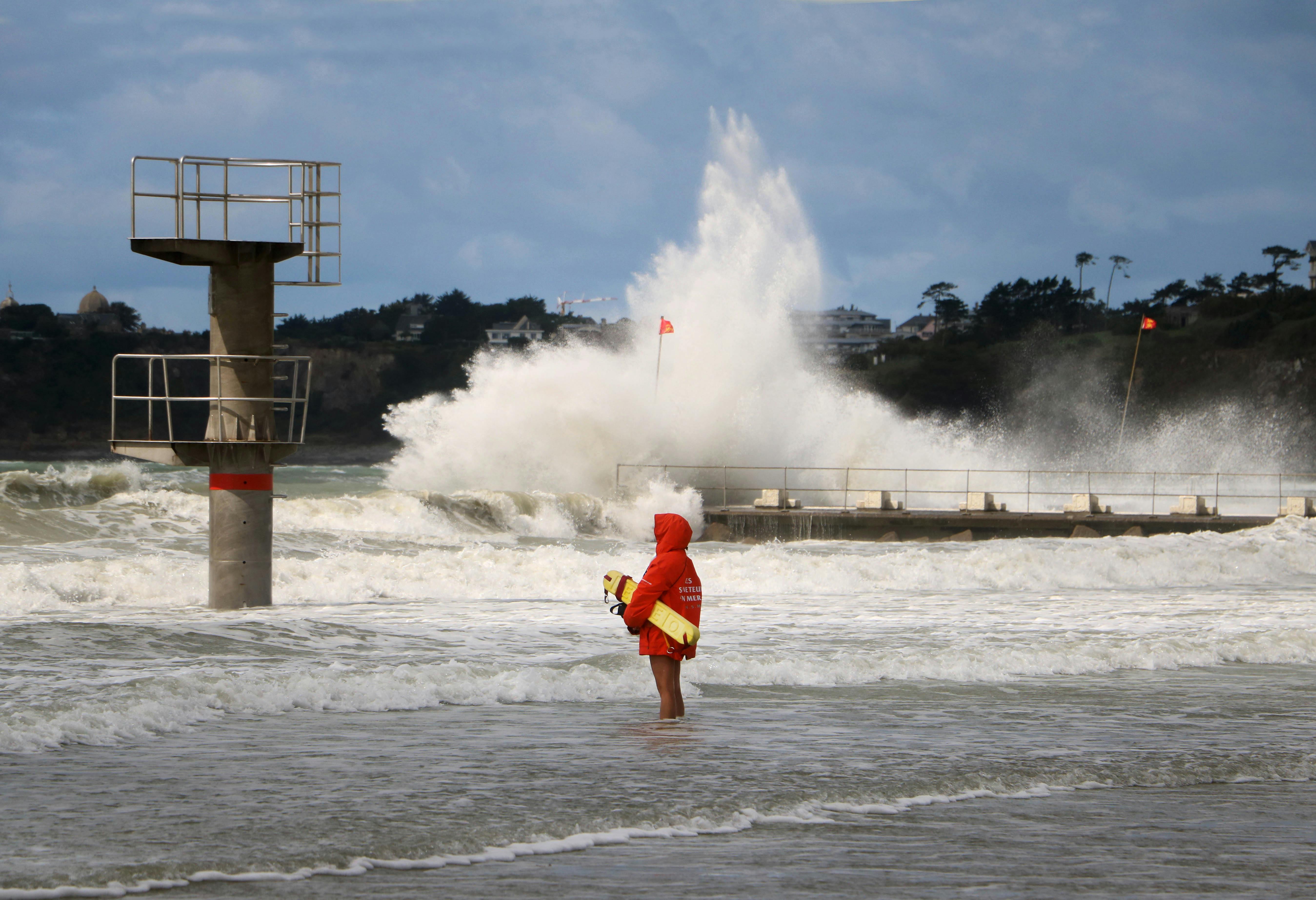 A Lifeguard Standing Knee Deep in Water on the Background of Large ...
