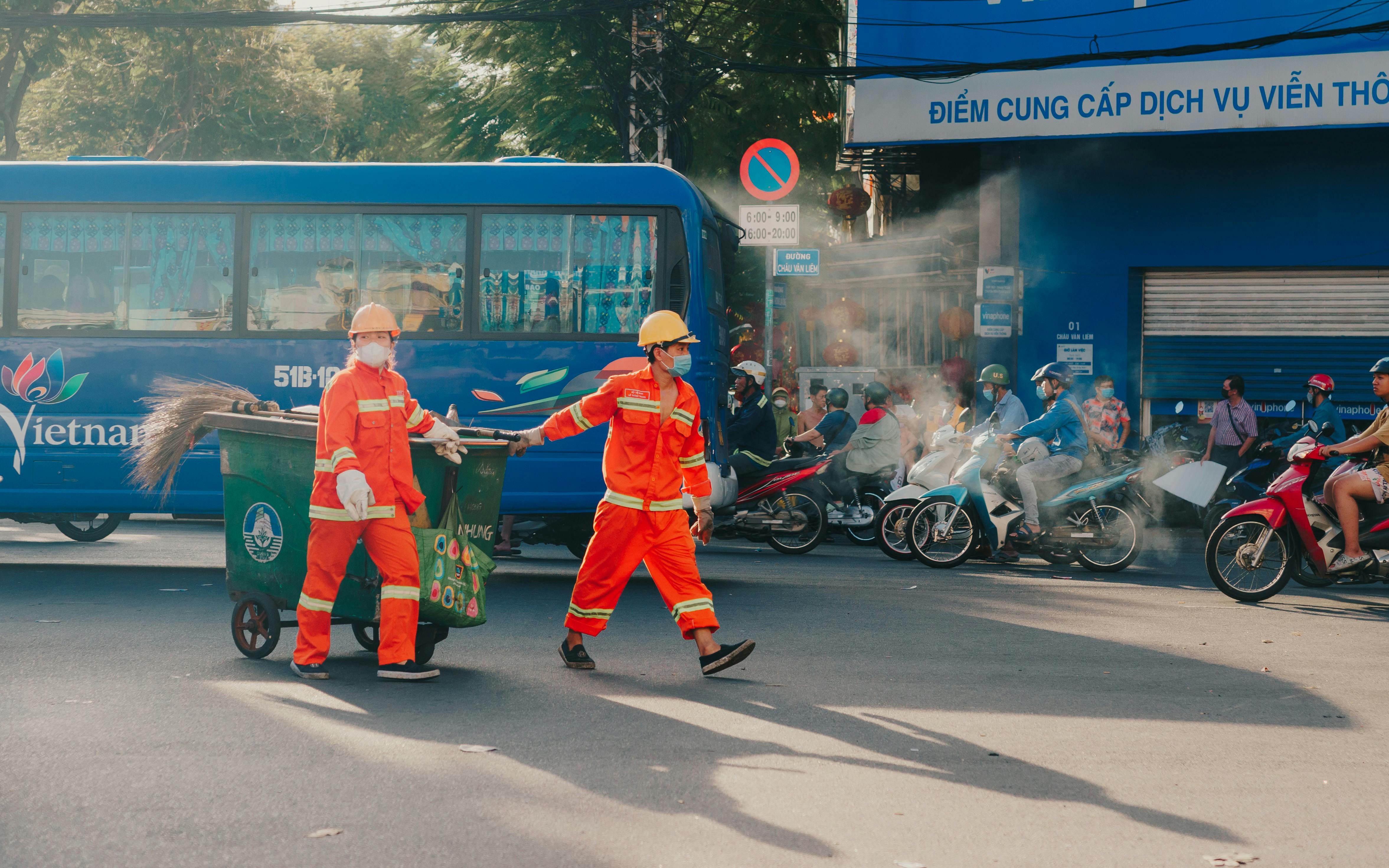 Workers Pulling a Garbage Bin on a Street in City · Free Stock Photo