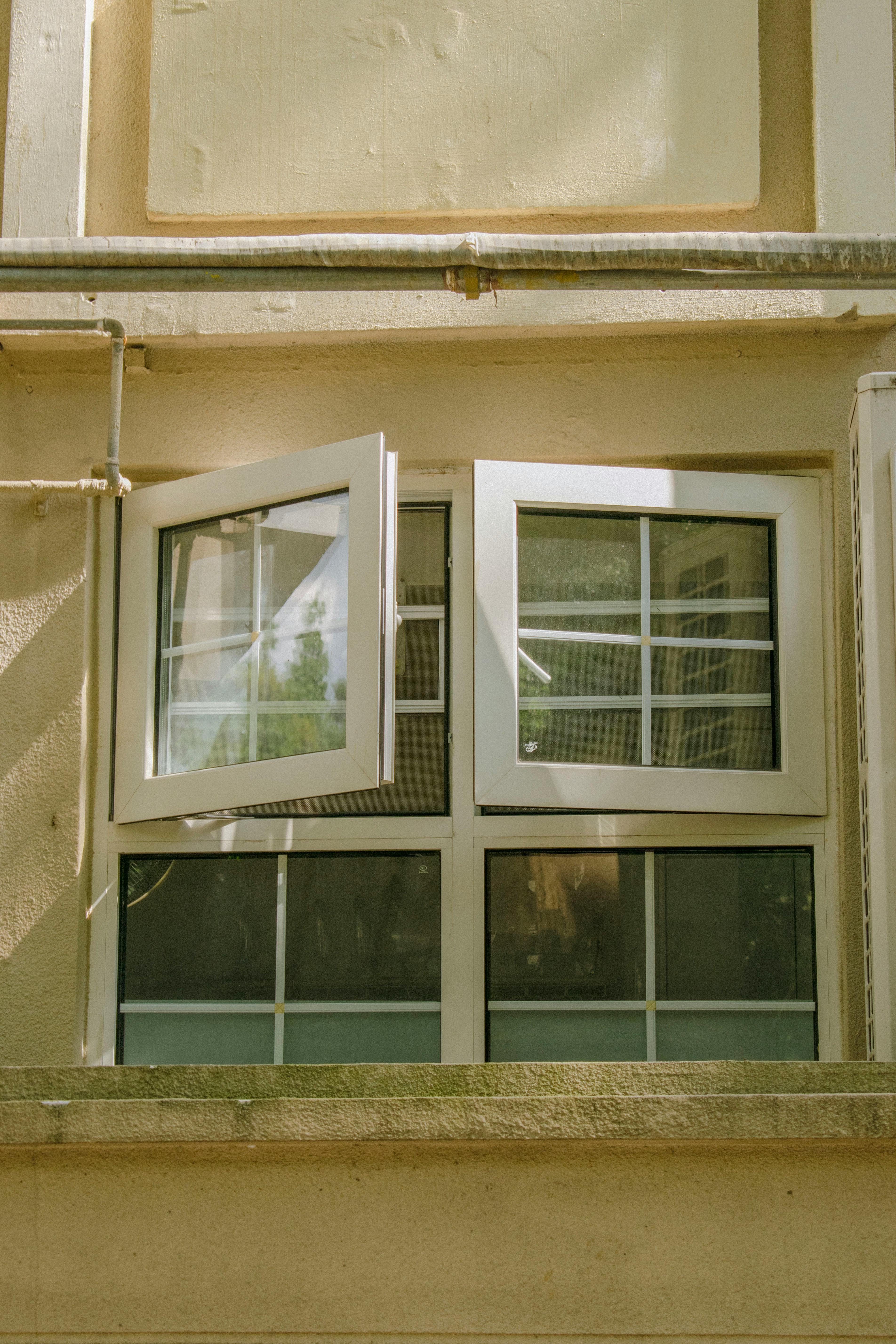 Town Buildings behind Window Opening in Stone Wall · Free Stock Photo