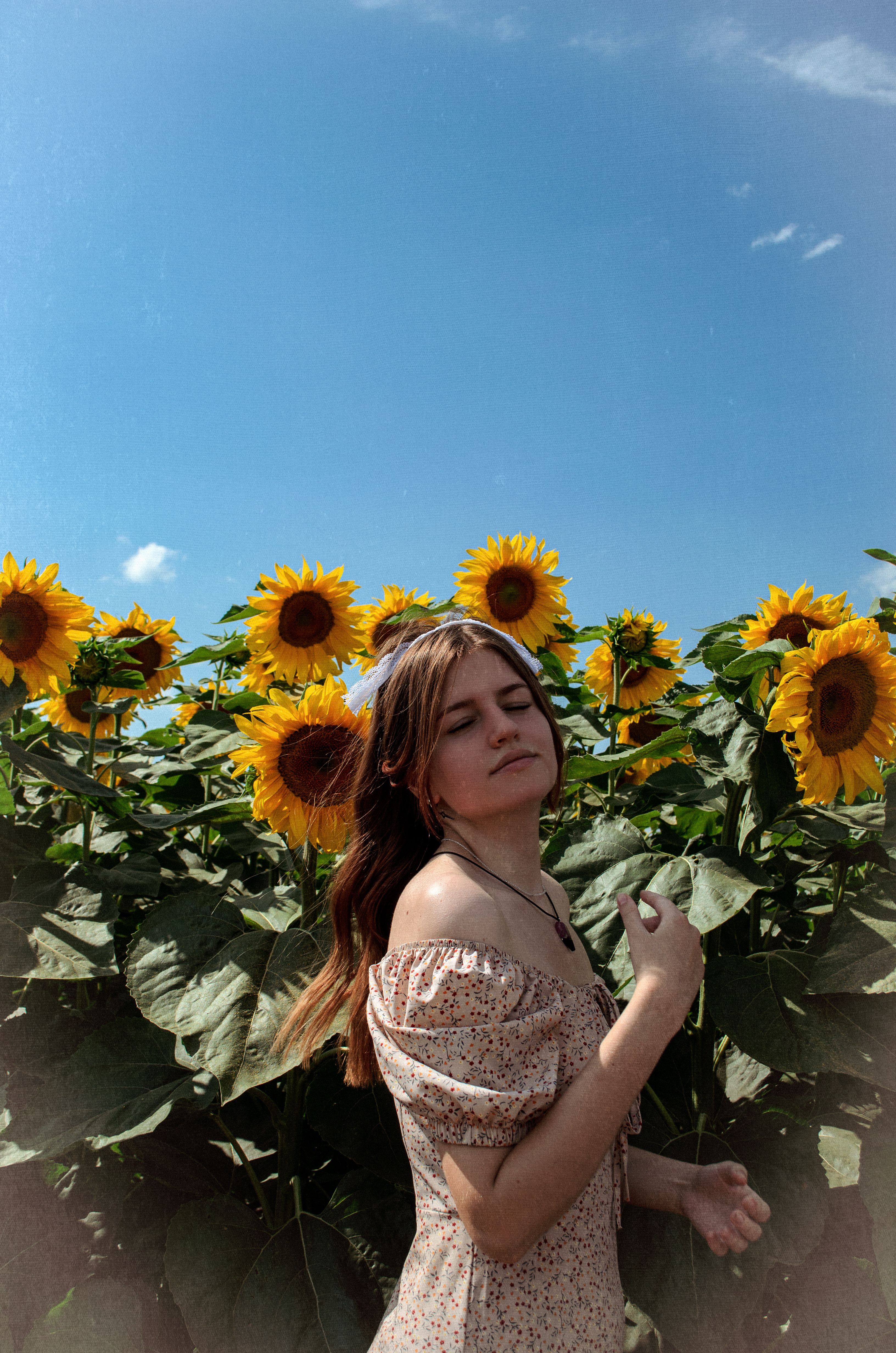 Woman in Sundress Standing with Sunflowers behind · Free Stock Photo