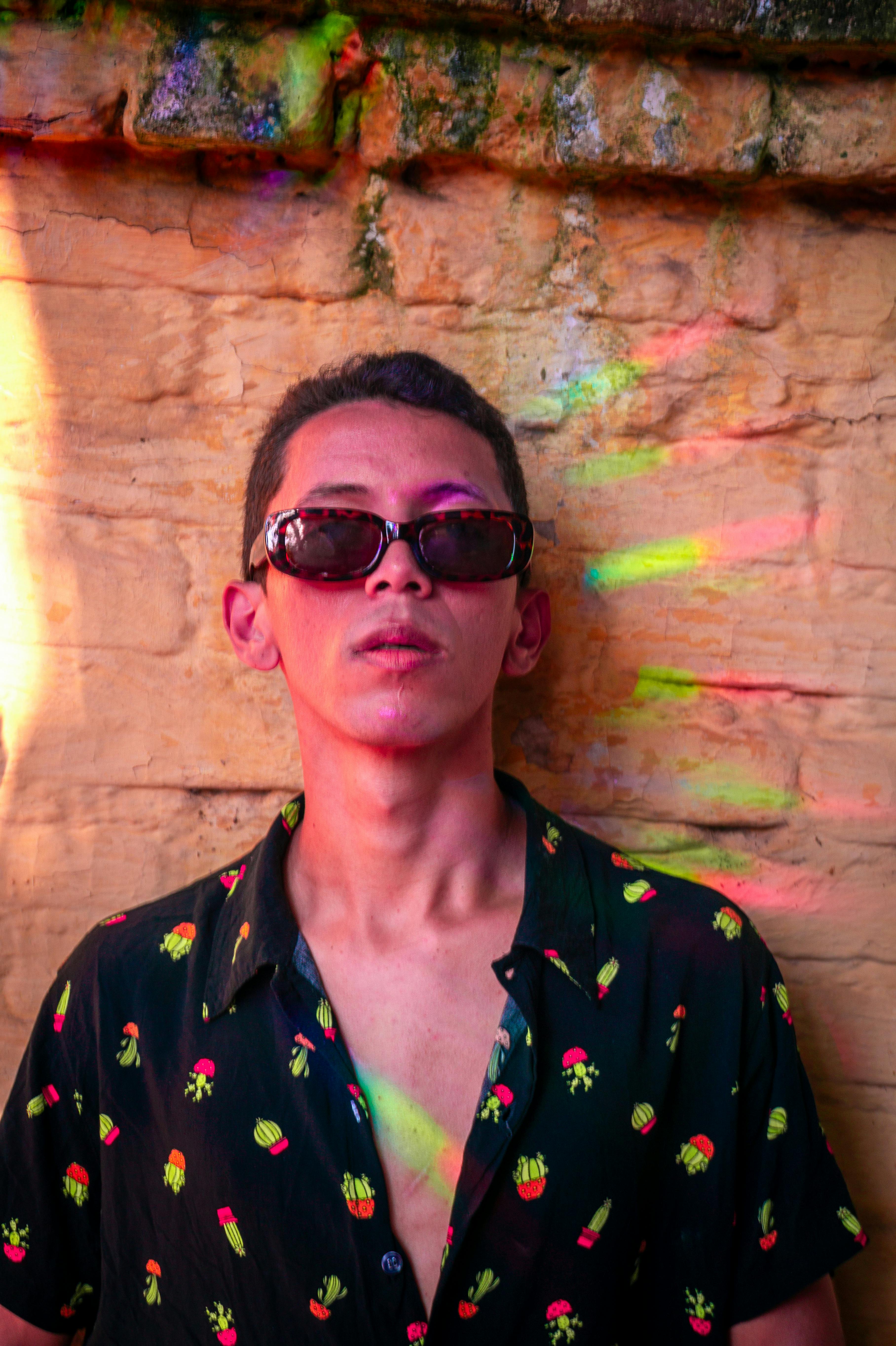 Man with Sunglasses in Black Shirt Posing by Wall · Free Stock Photo