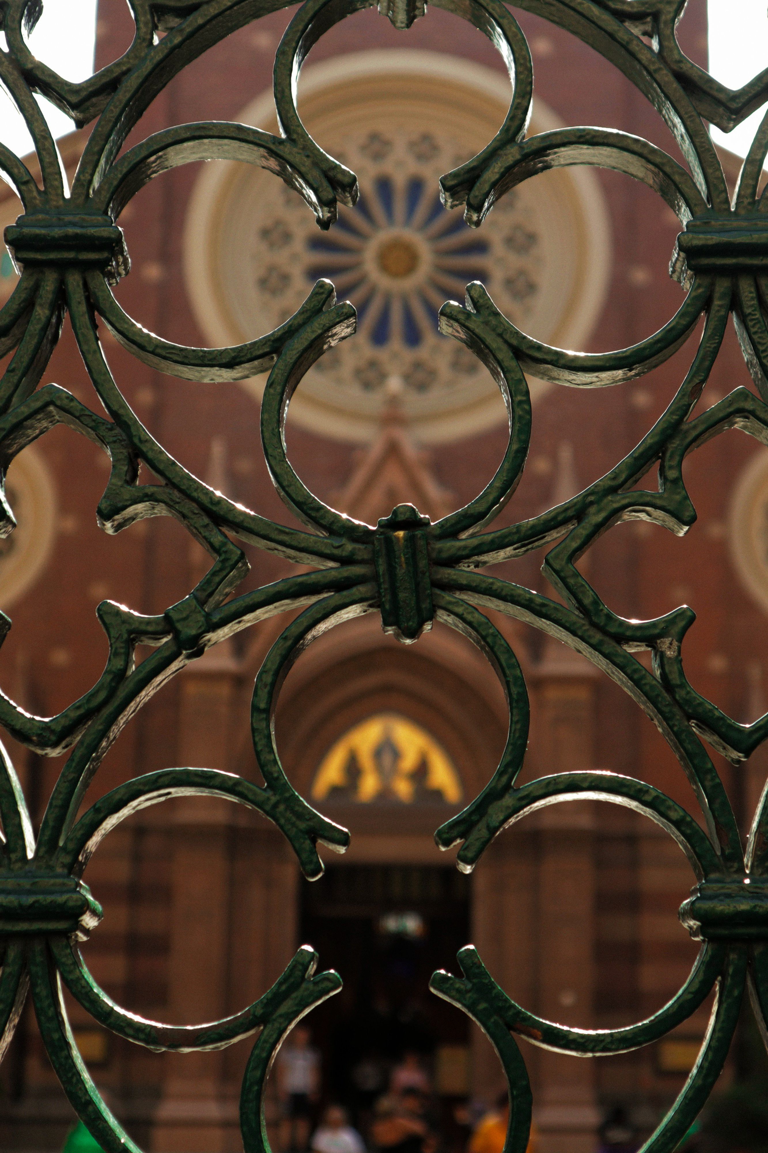 A close up of a metal gate with a clock · Free Stock Photo