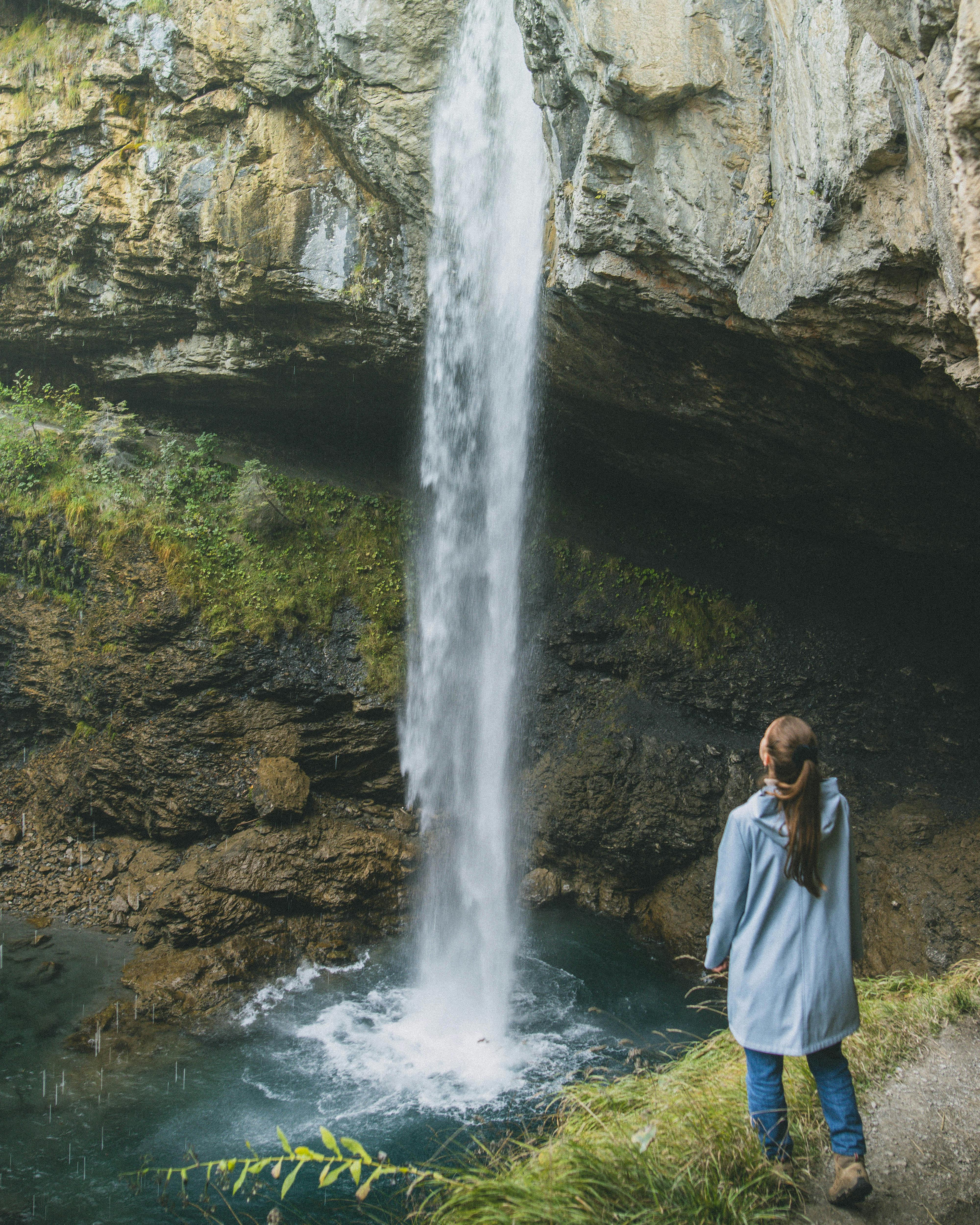 Woman Standing on Path under Waterfall · Free Stock Photo