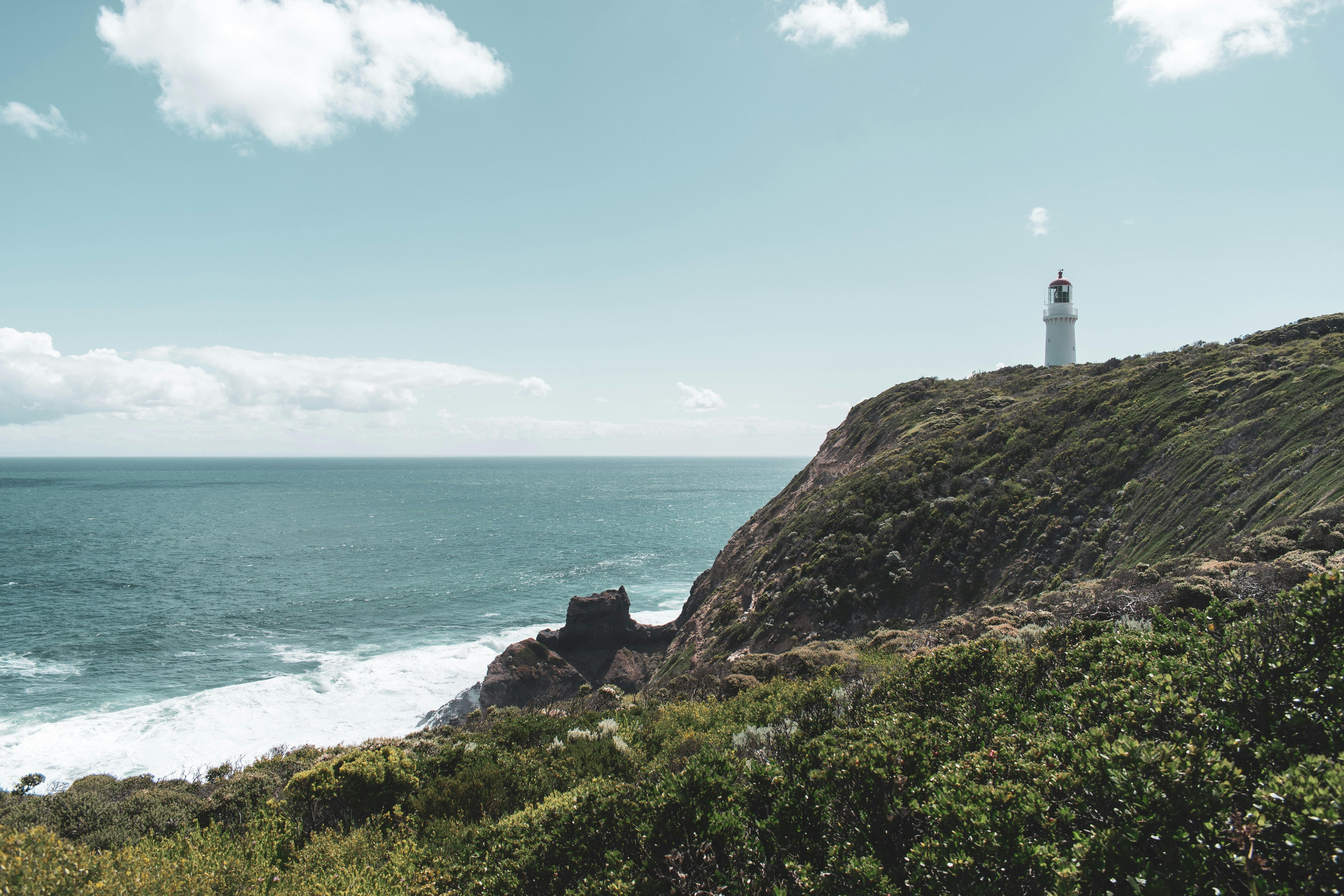 Photo of a Coast with a Lighthouse · Free Stock Photo