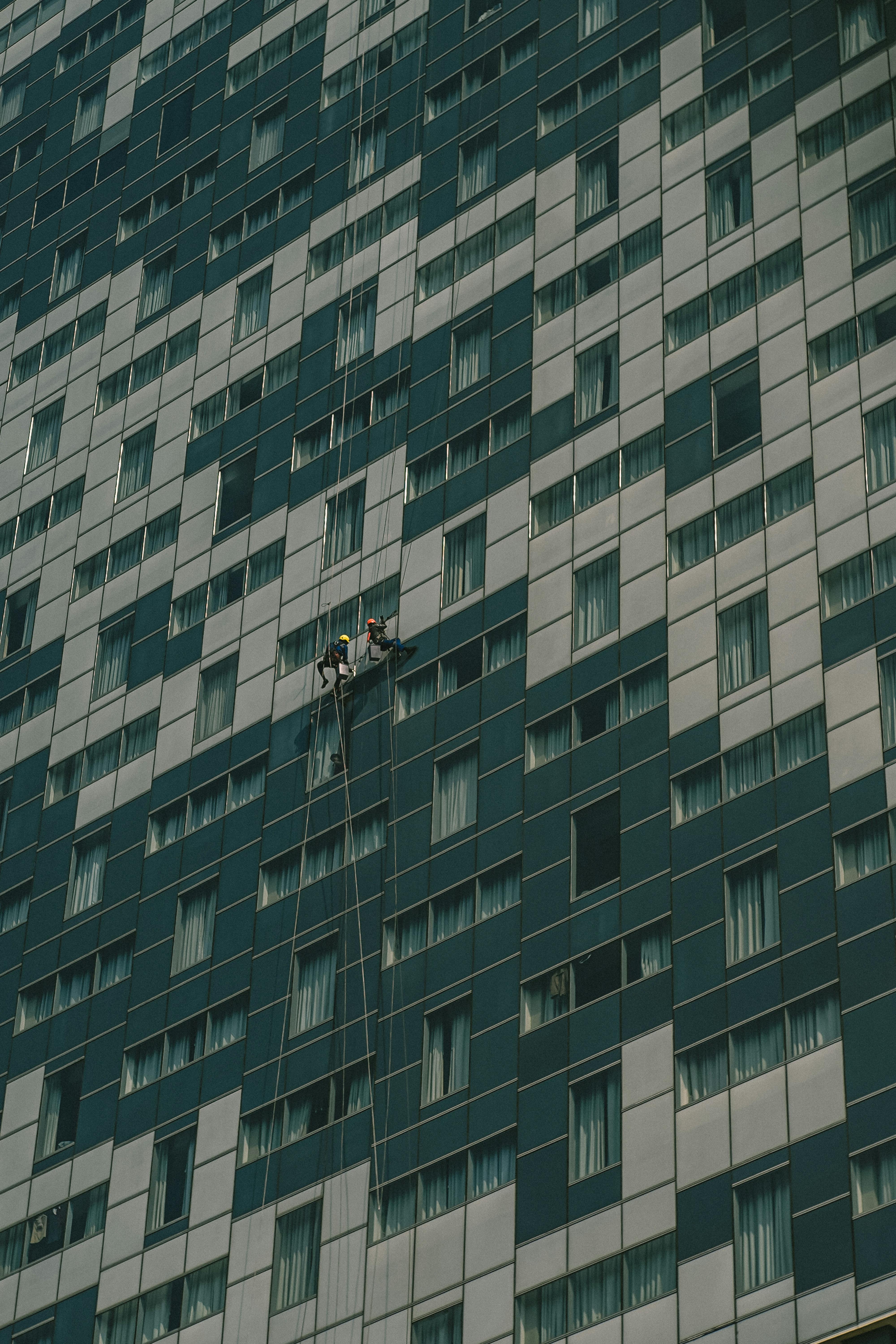Men Working High on the Facade of a Skyscraper · Free Stock Photo