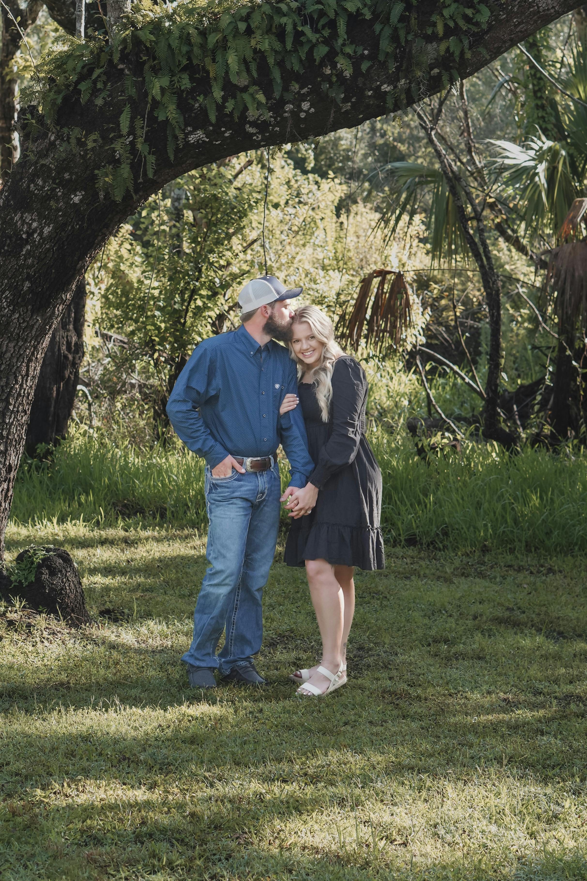 Una Pareja Recién Comprometida Parada Bajo Un árbol · Foto de stock ...