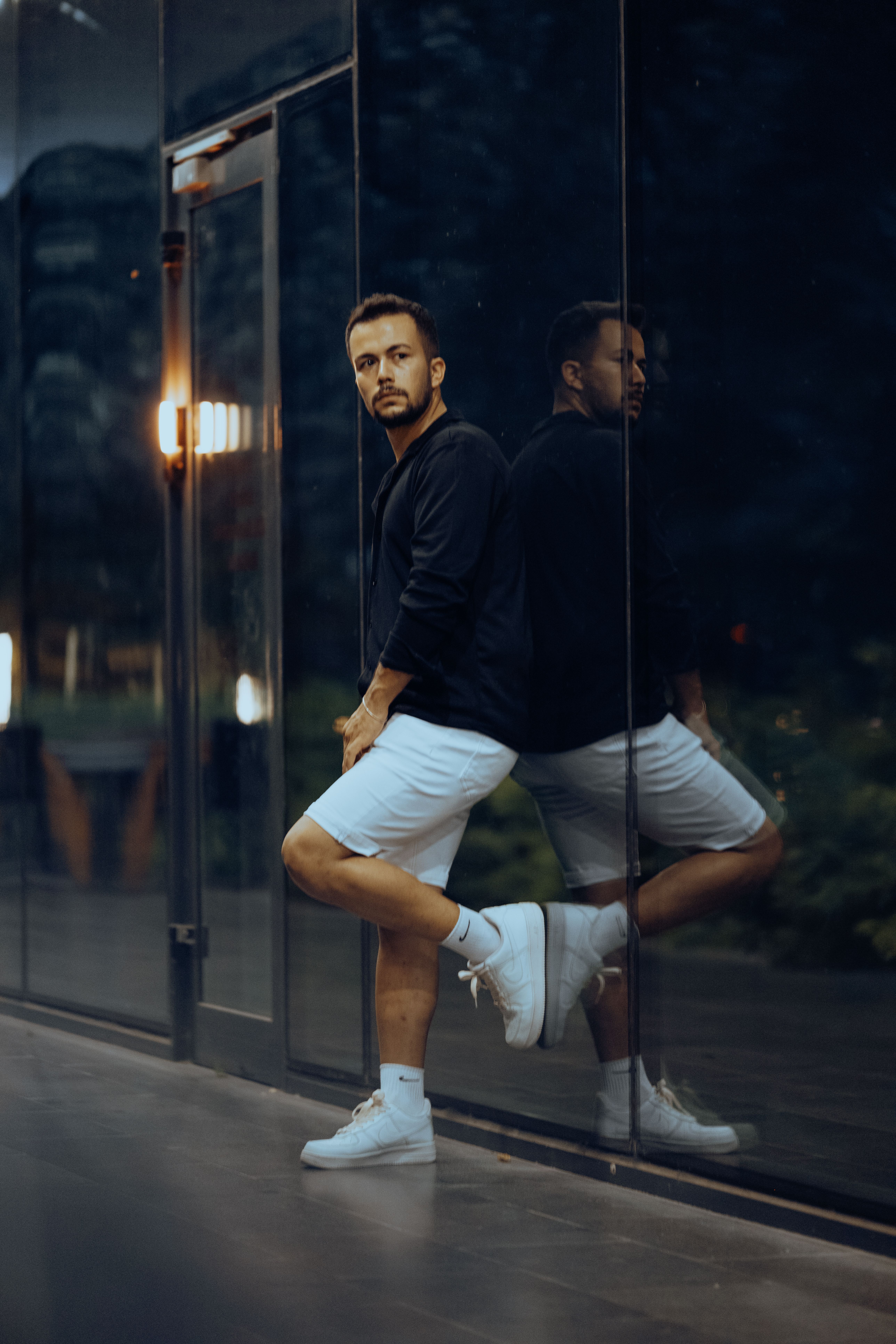 Man Leaning against Glass Wall · Free Stock Photo