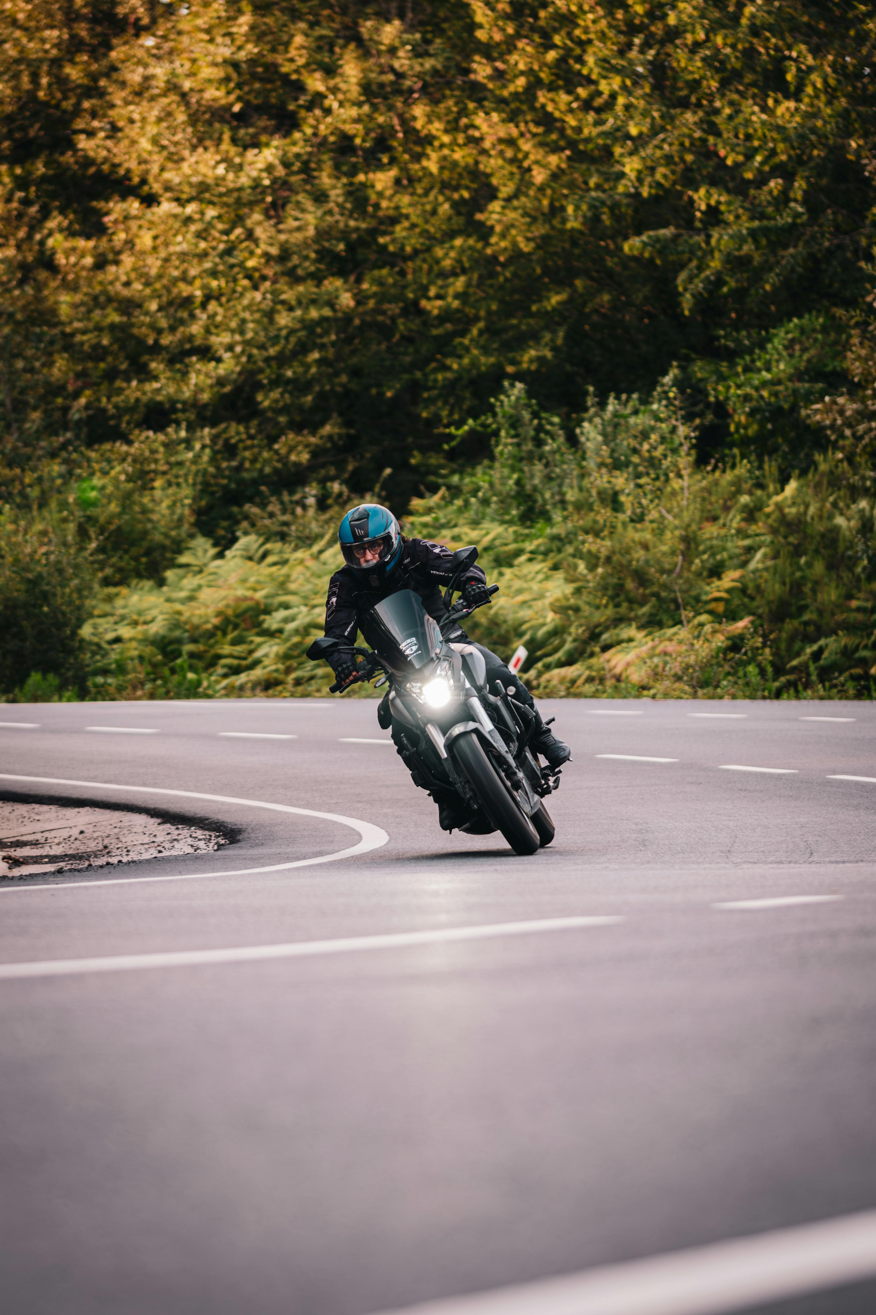 Man Riding Motorbike on Road in Forest · Free Stock Photo