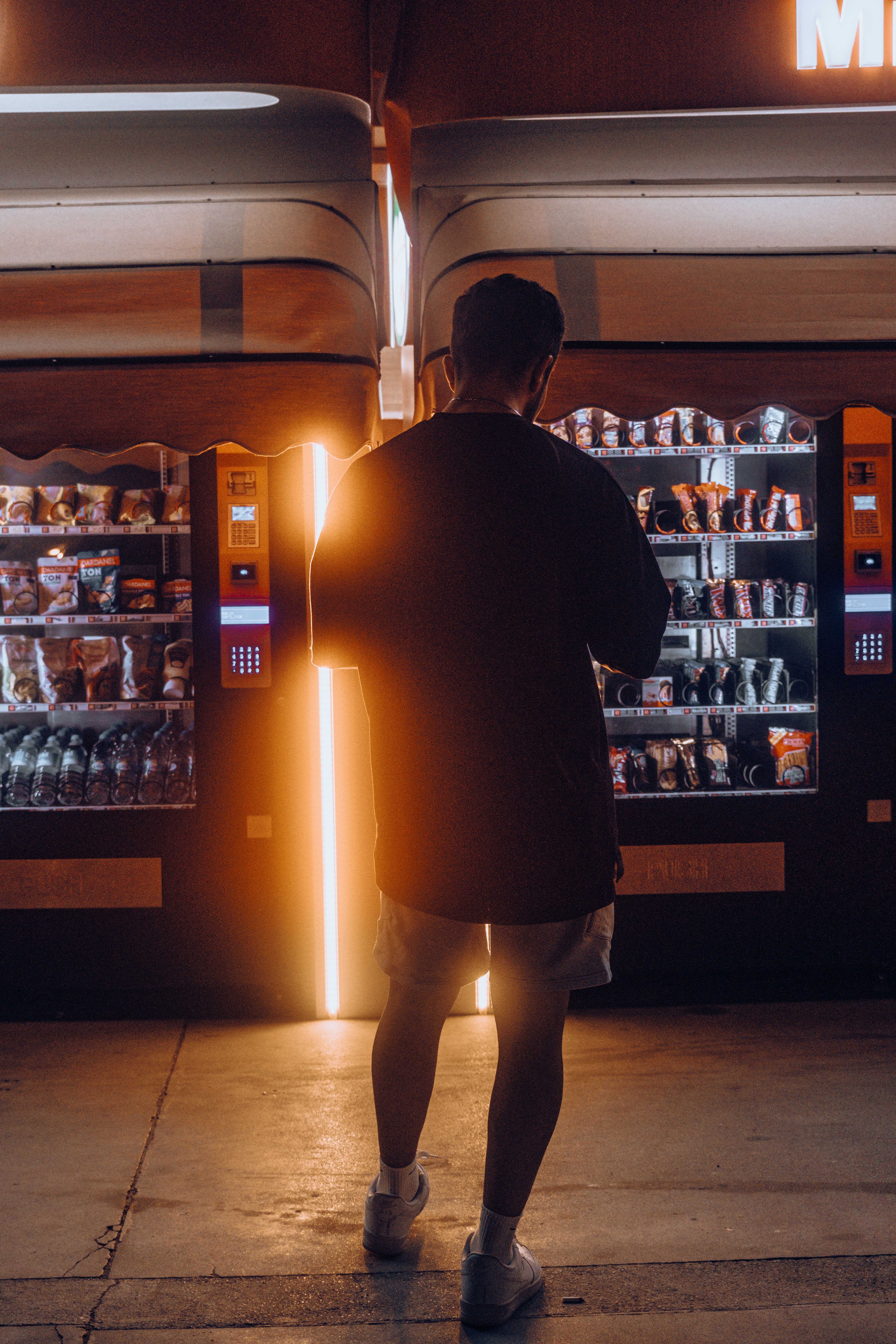Man Standing near Vending Machines · Free Stock Photo