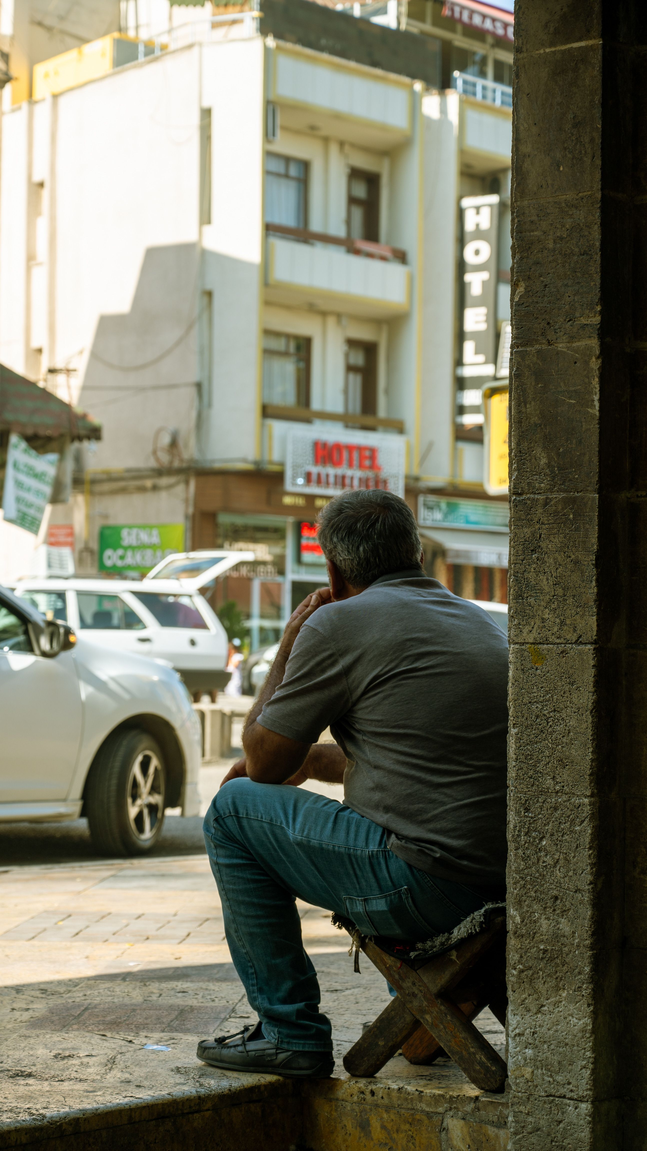 Man Sitting on Curb and Holding Dog on Leash · Free Stock Photo