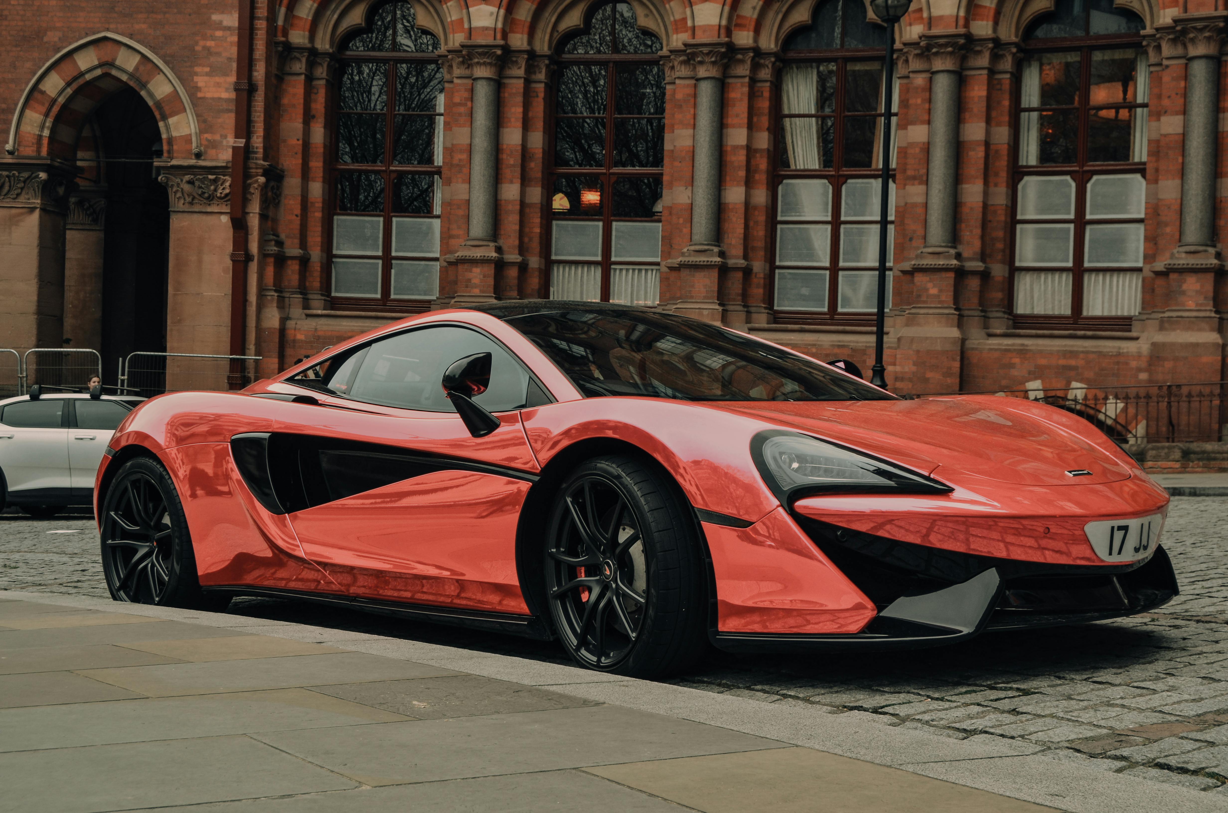 Red McLaren 570GT Car Parked by Building Entrance · Free Stock Photo