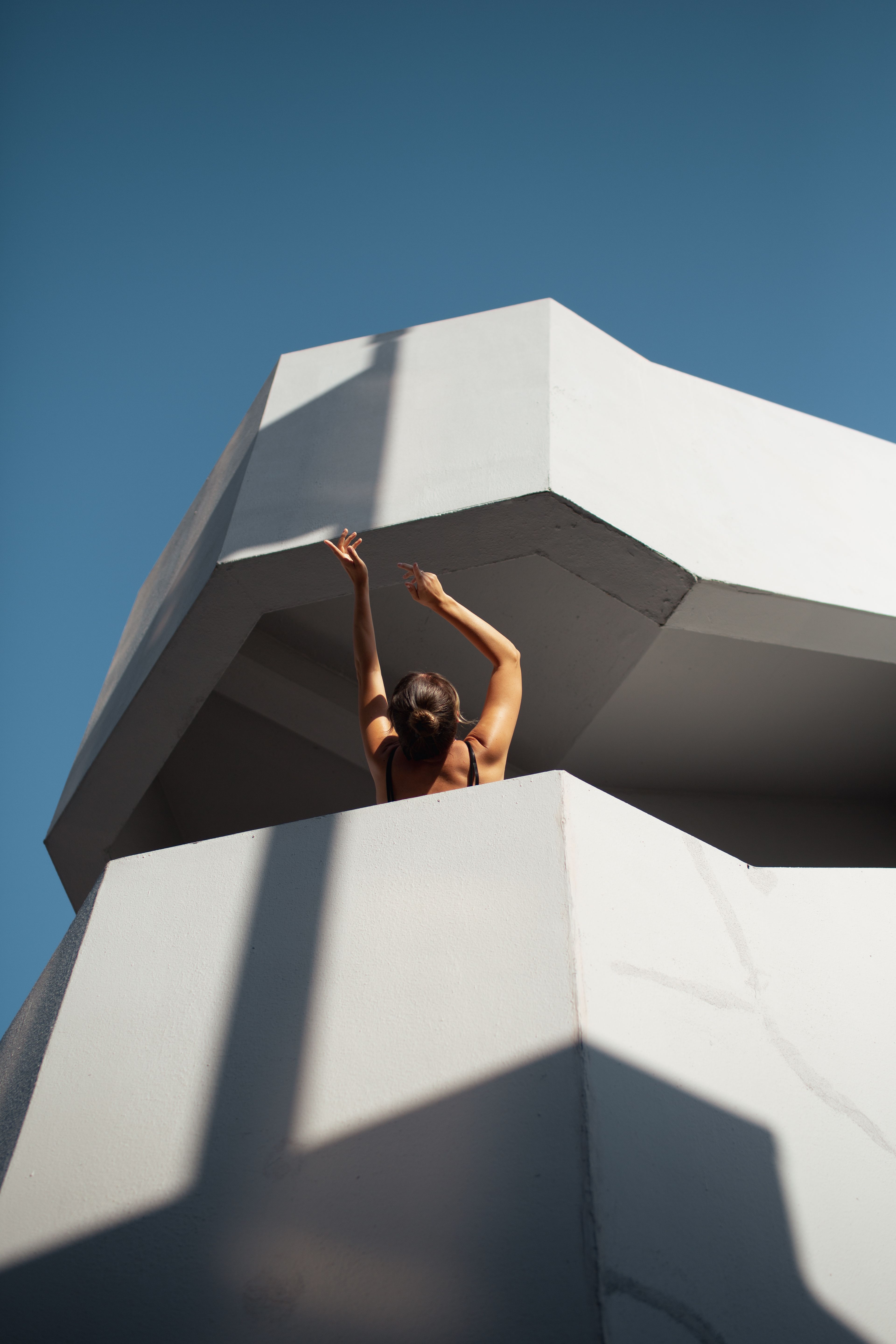Woman on Balcony of Modern Residential Building · Free Stock Photo