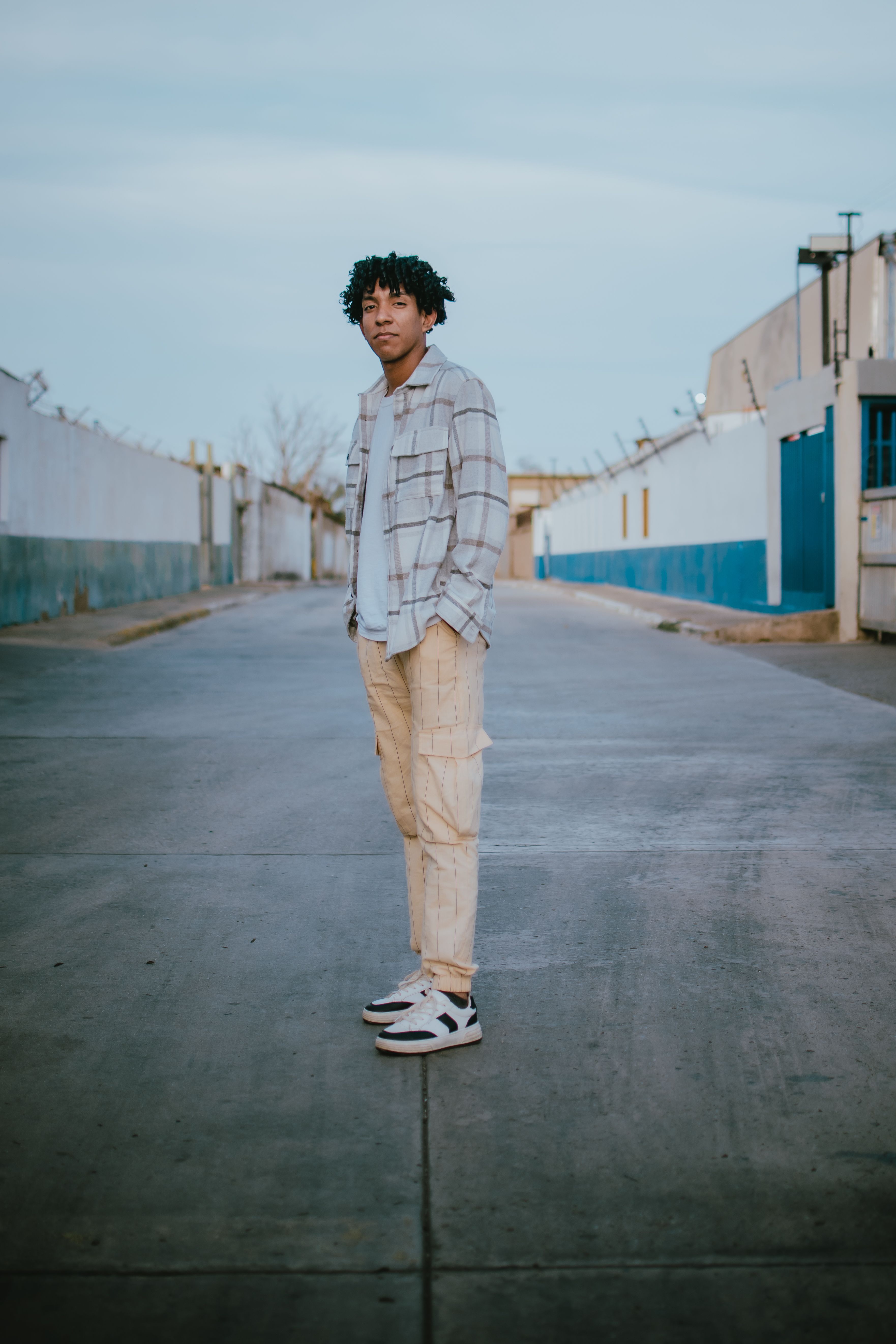 Young Man in Jacket and Sneakers Standing in Middle of Empty Street ...