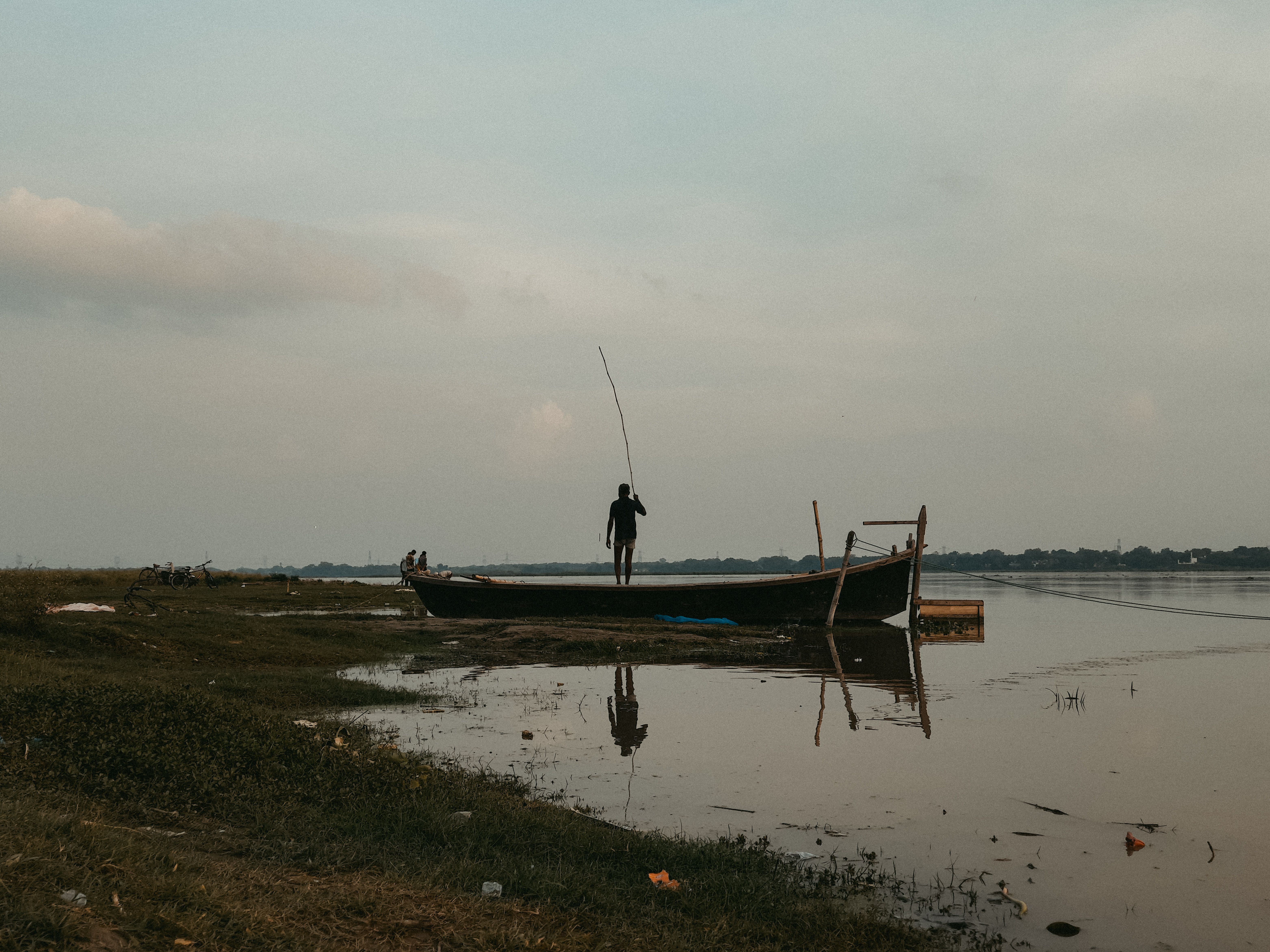 Angler Fishing from a Boat on the Riverbank · Free Stock Photo