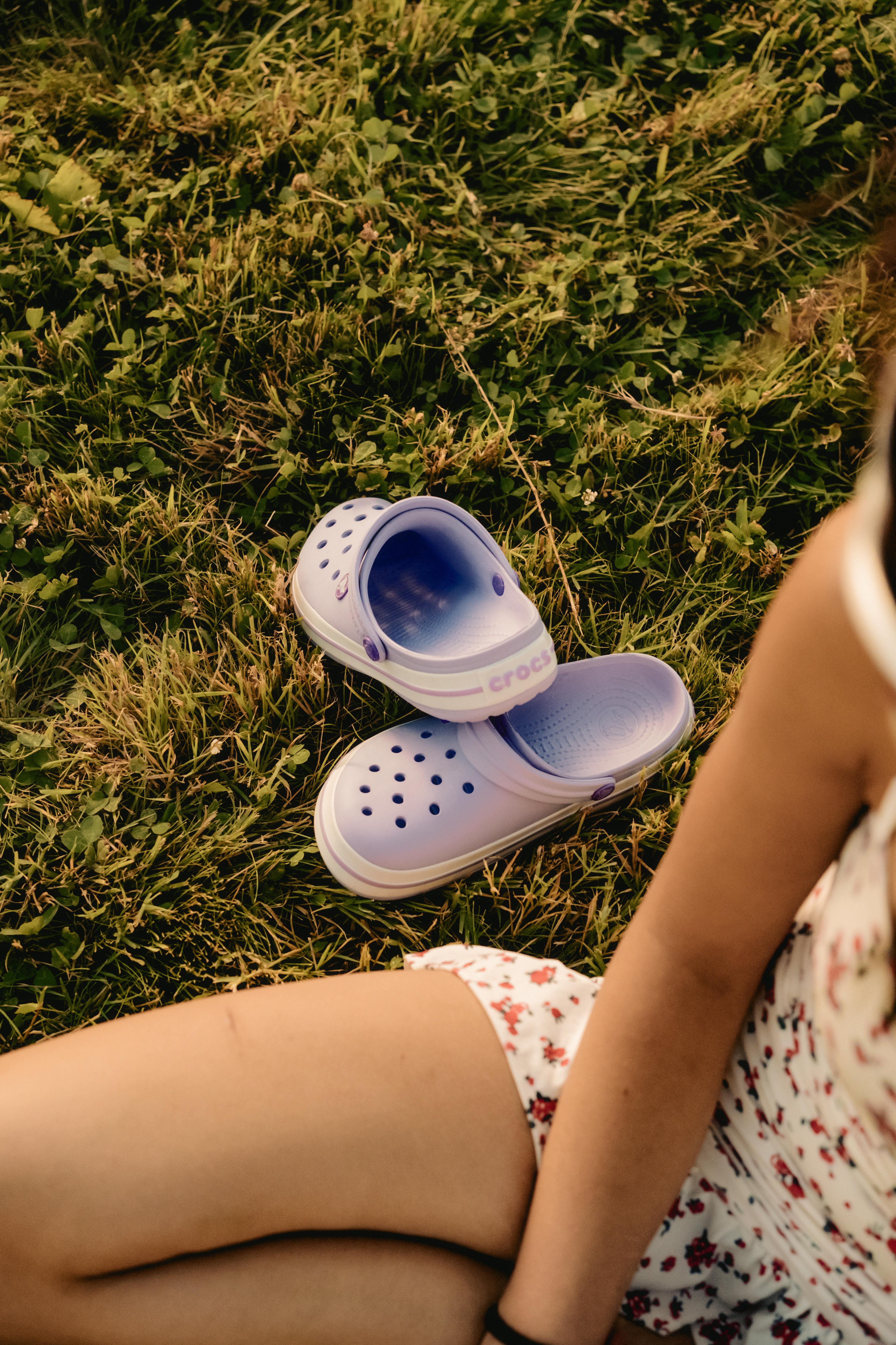 Purple Crocs Lying Near Woman in Dress · Free Stock Photo