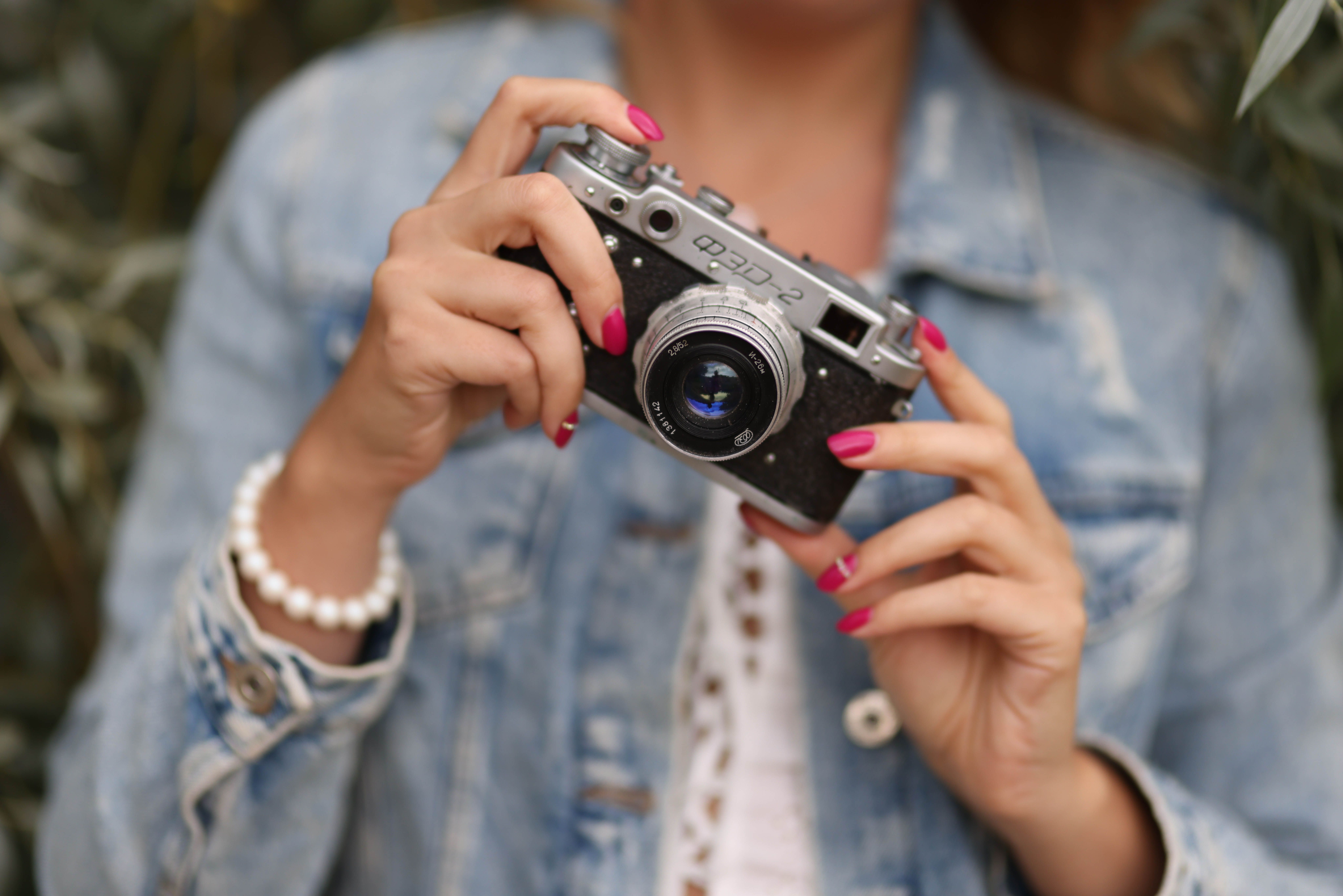 Woman Holding a Camera Sitting on Bench · Free Stock Photo