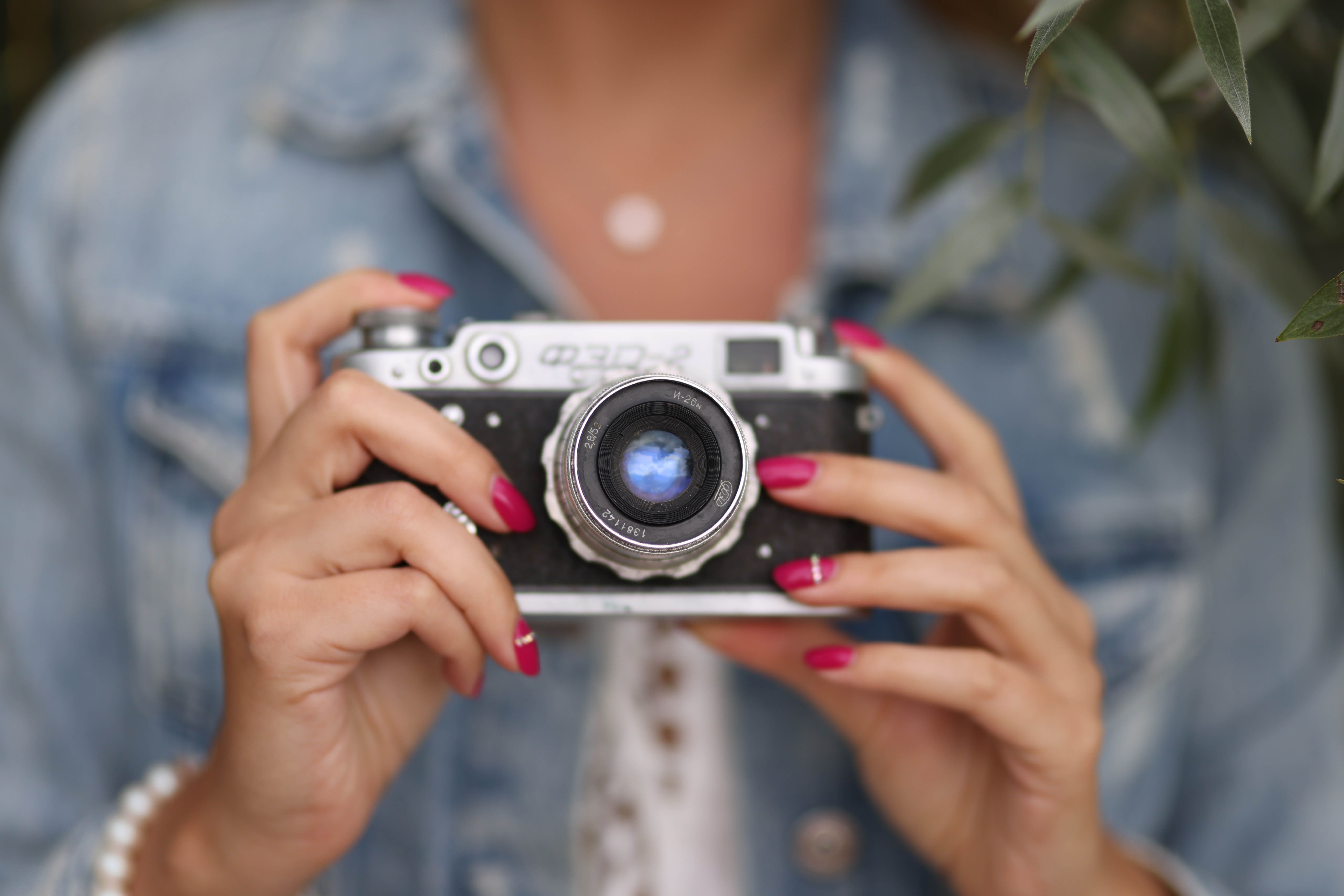 Woman Holding a Camera Sitting on Bench · Free Stock Photo