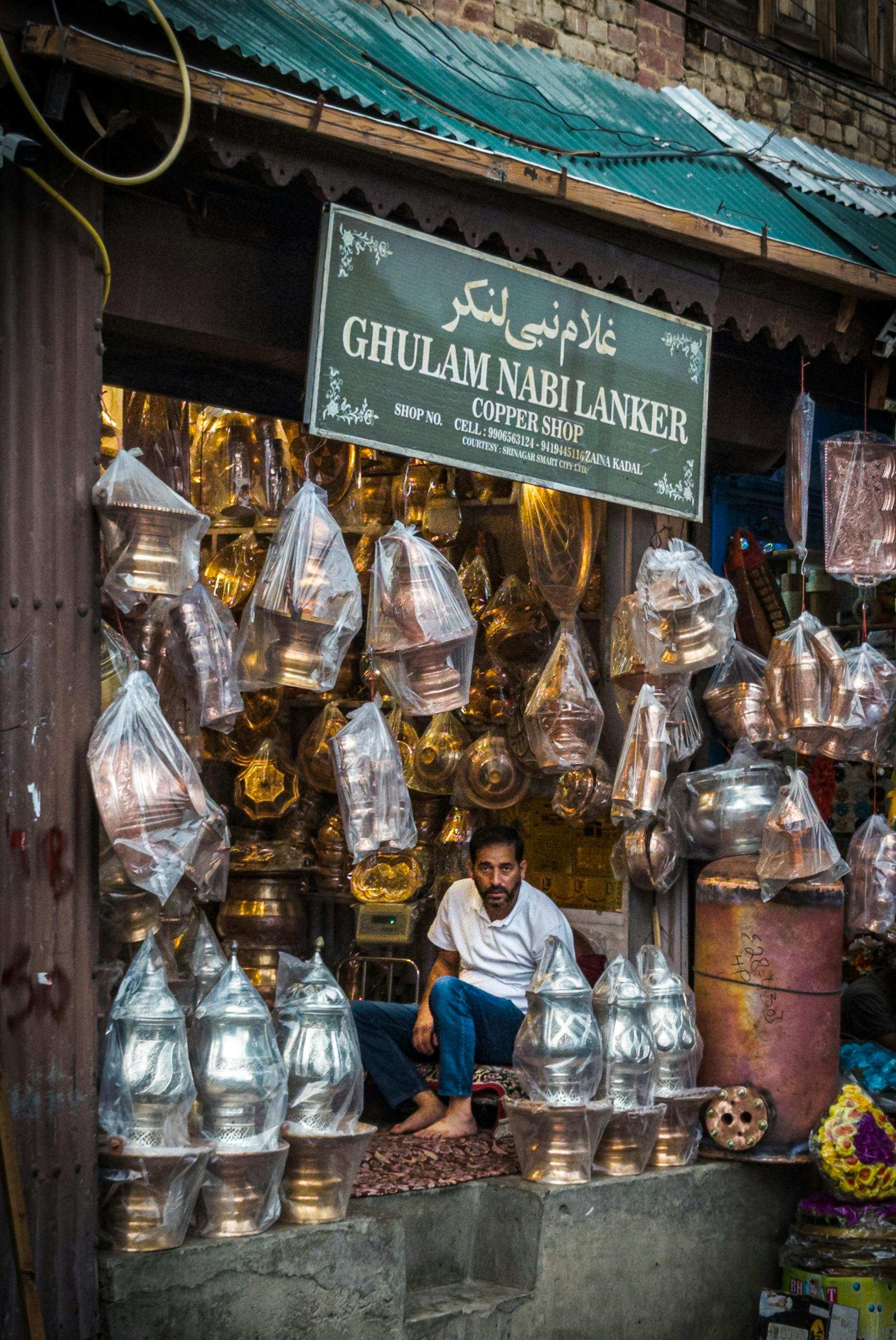 Man Sitting in Copper Shop · Free Stock Photo
