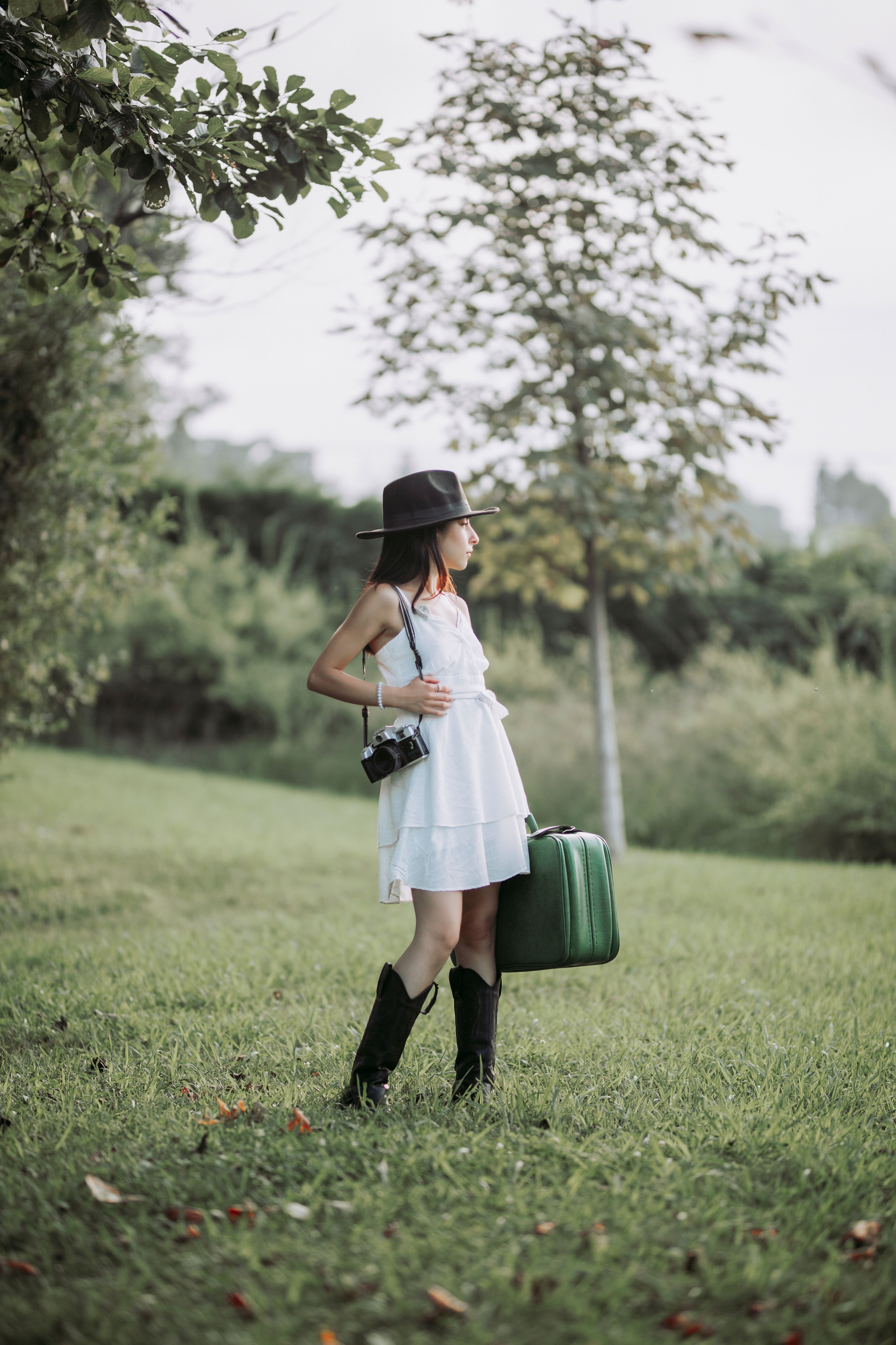 Woman in White Sundress and Cowboy Boots Holding Suitcase · Free Stock ...