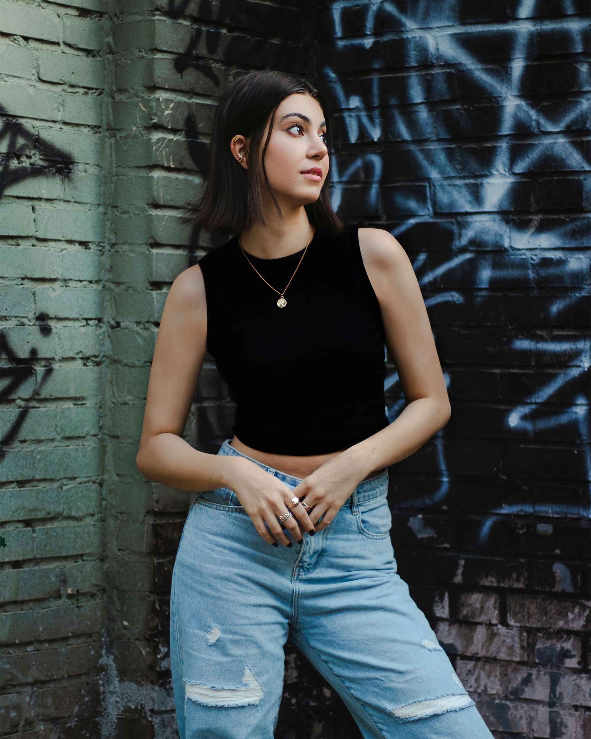 Woman in Distressed Jeans Posing against Mural · Free Stock Photo