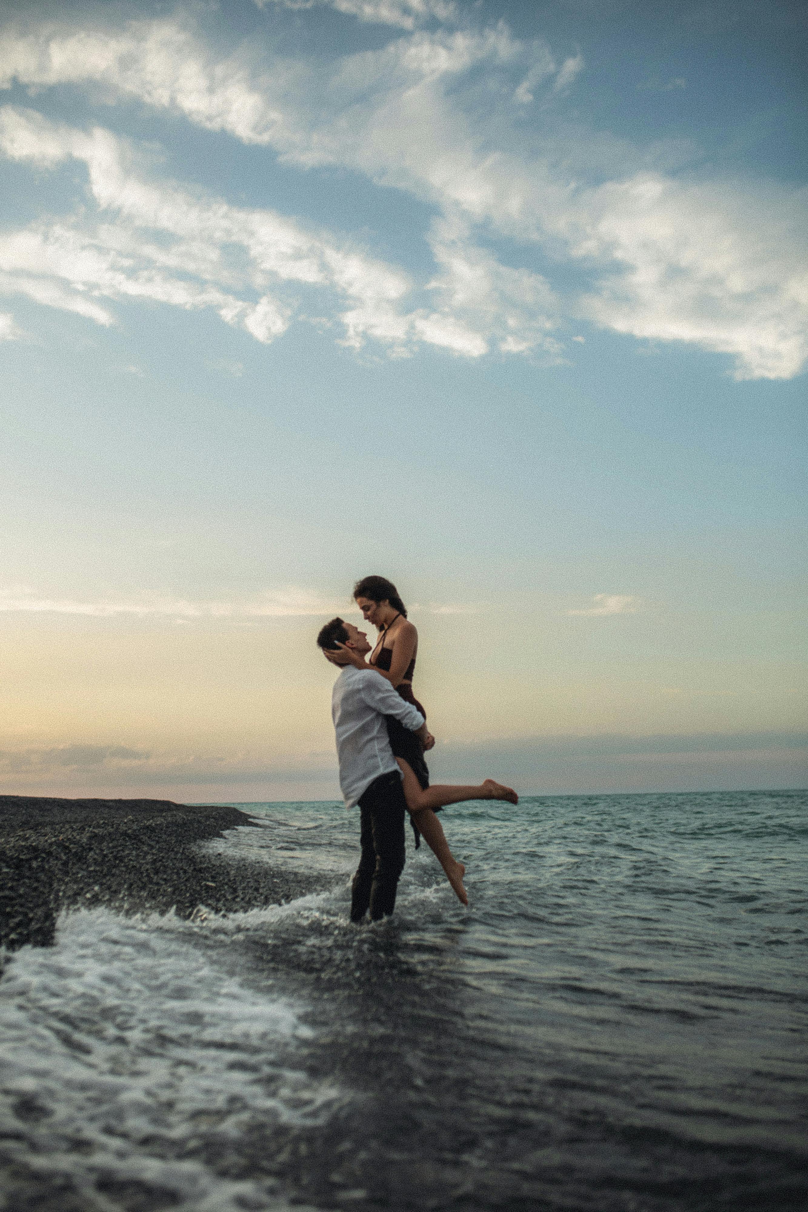 Affectionate Couple in Sea at Dawn · Free Stock Photo