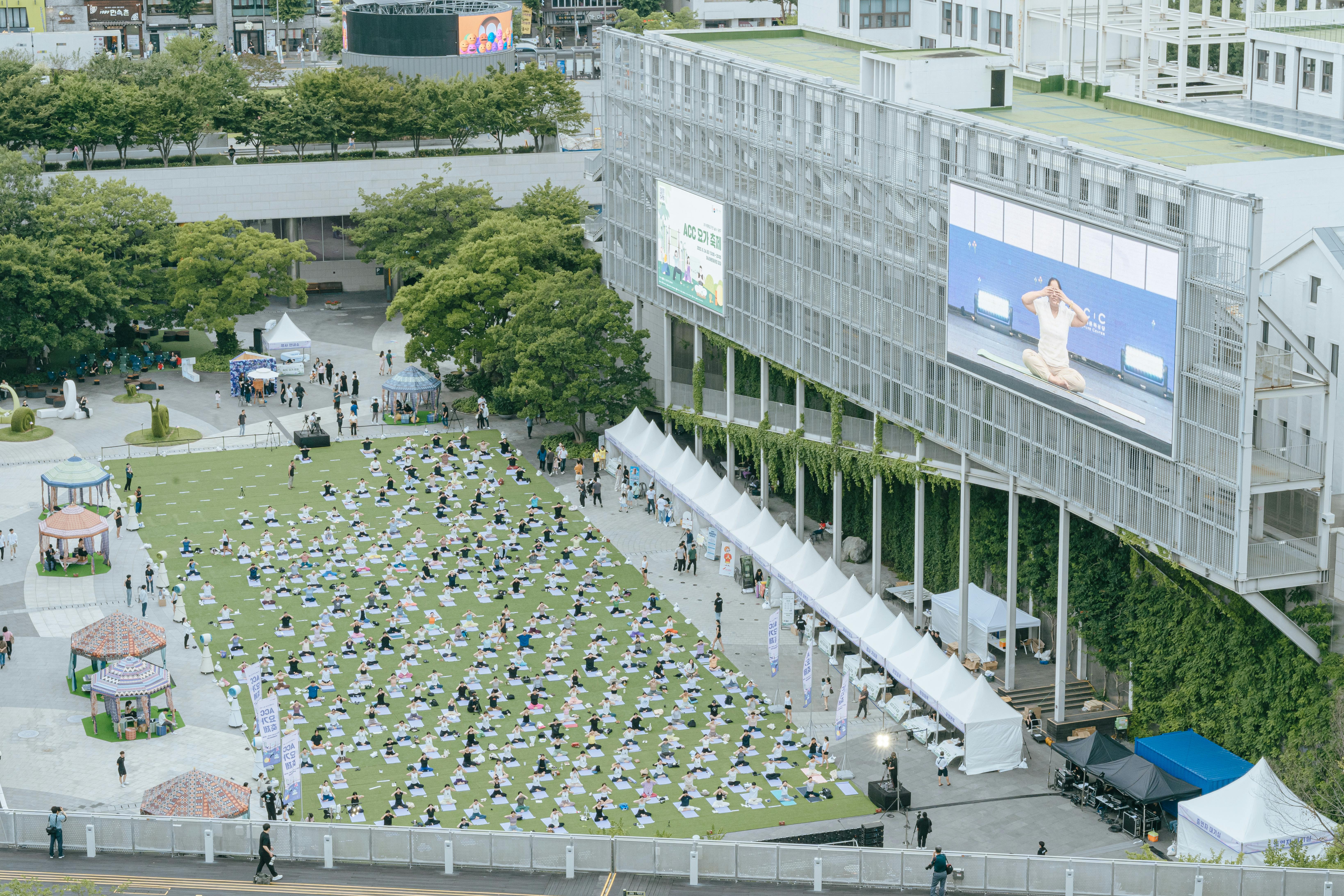 People on Yoga Mats and Stalls in the Square of the National Asian ...