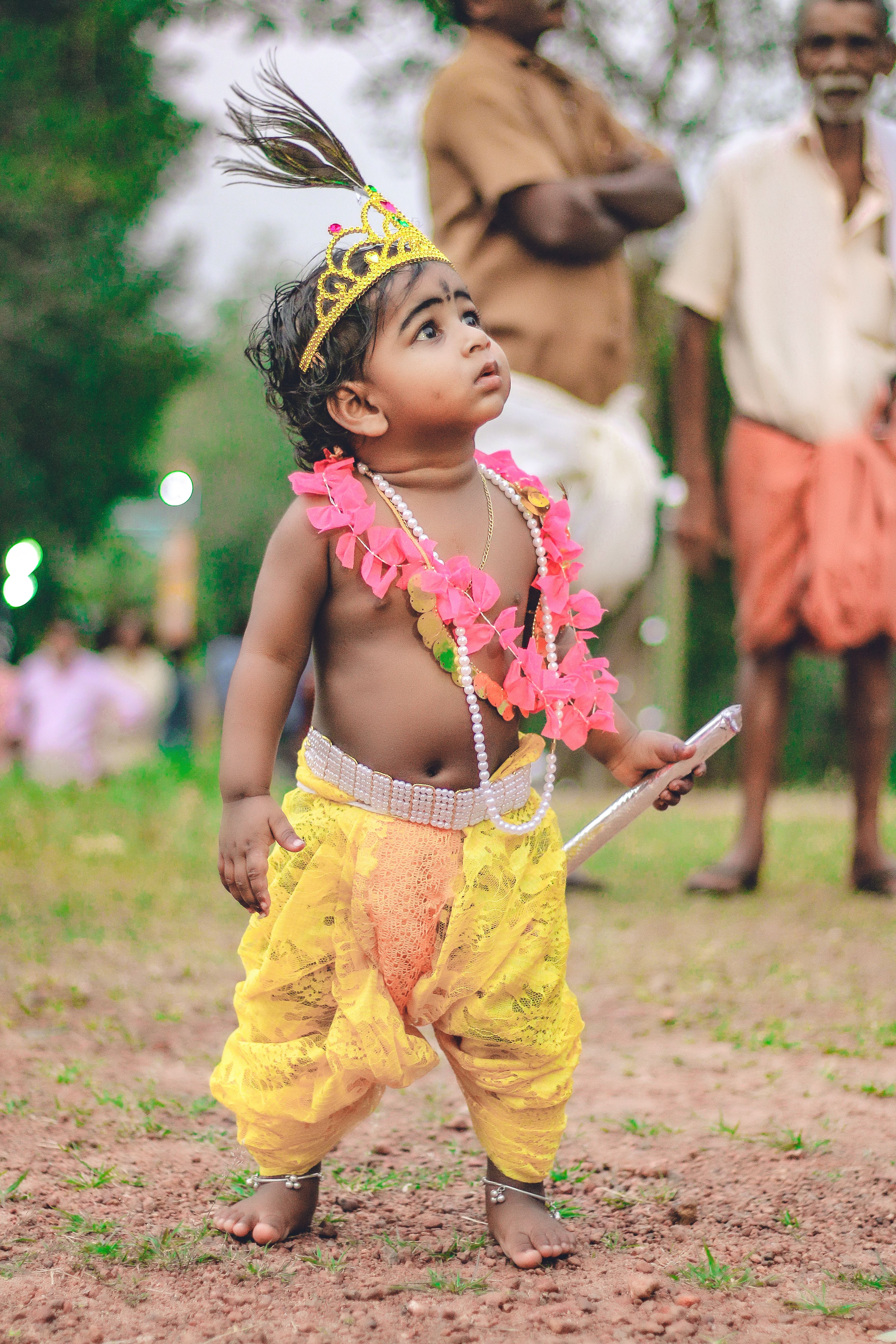 Child in Traditional Clothing with Garland and Crown with Feather ...