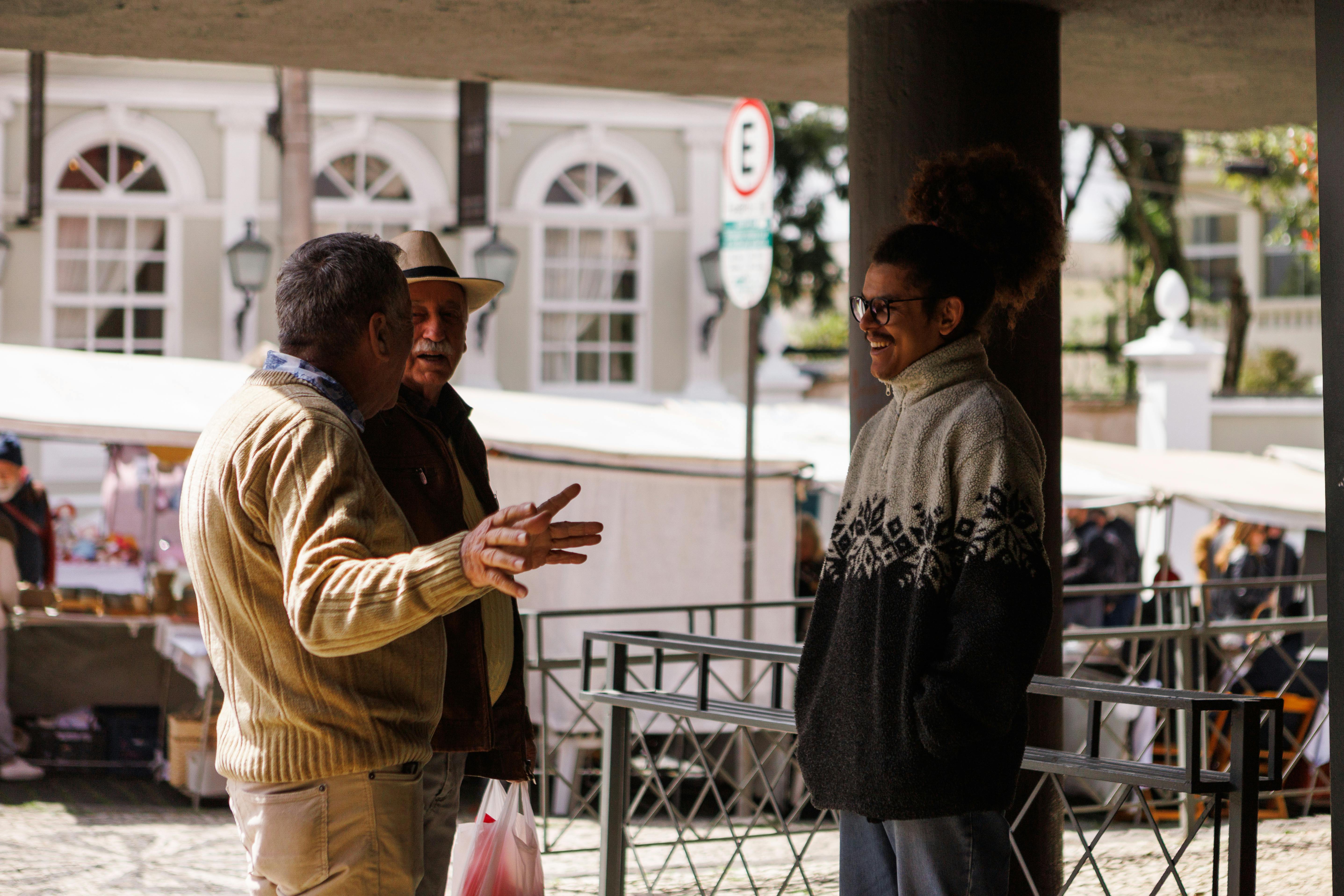 Three People Talking in a City · Free Stock Photo