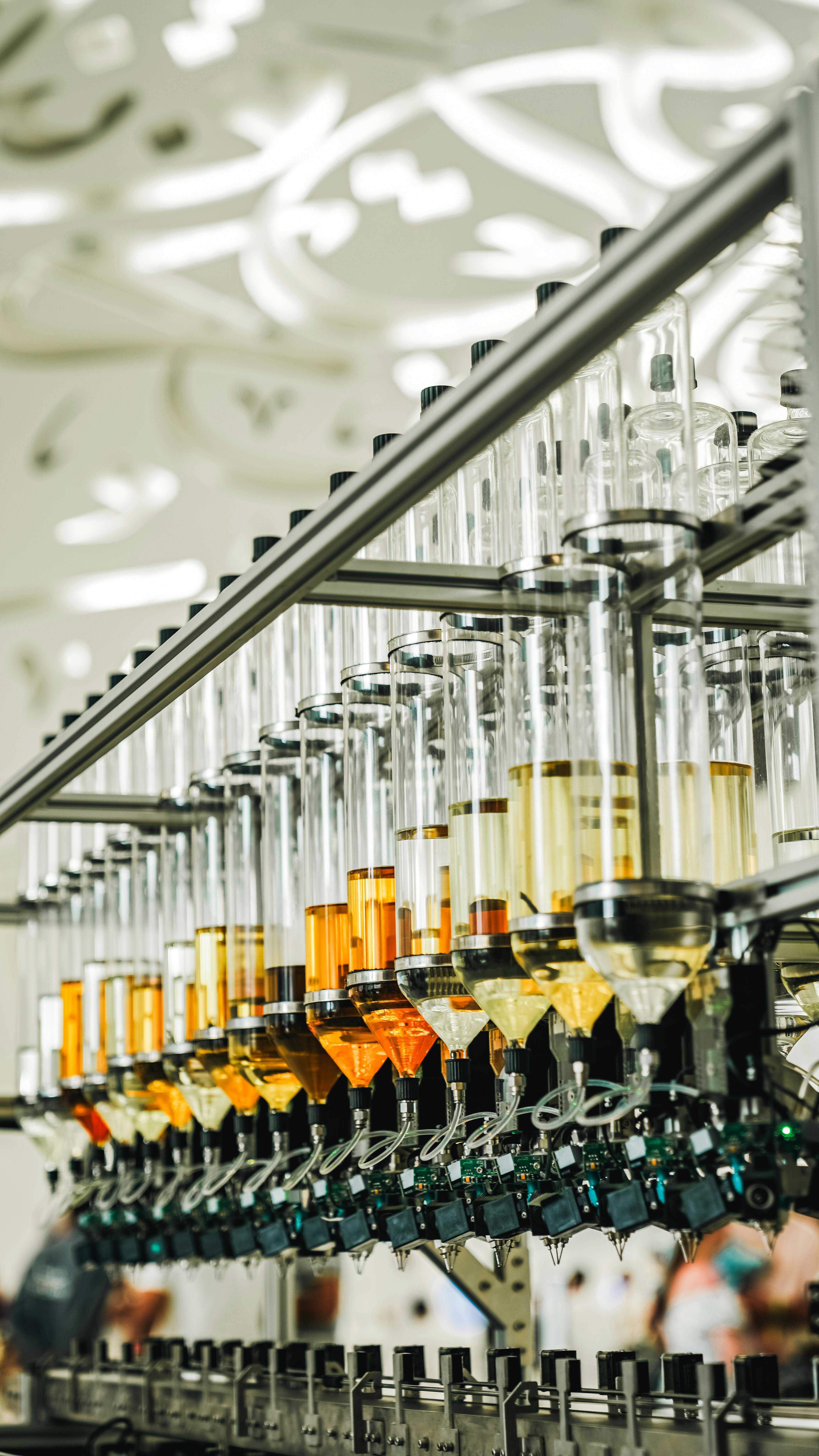 A Machine with Bottles with Liquid at a Bottling Company · Free Stock Photo