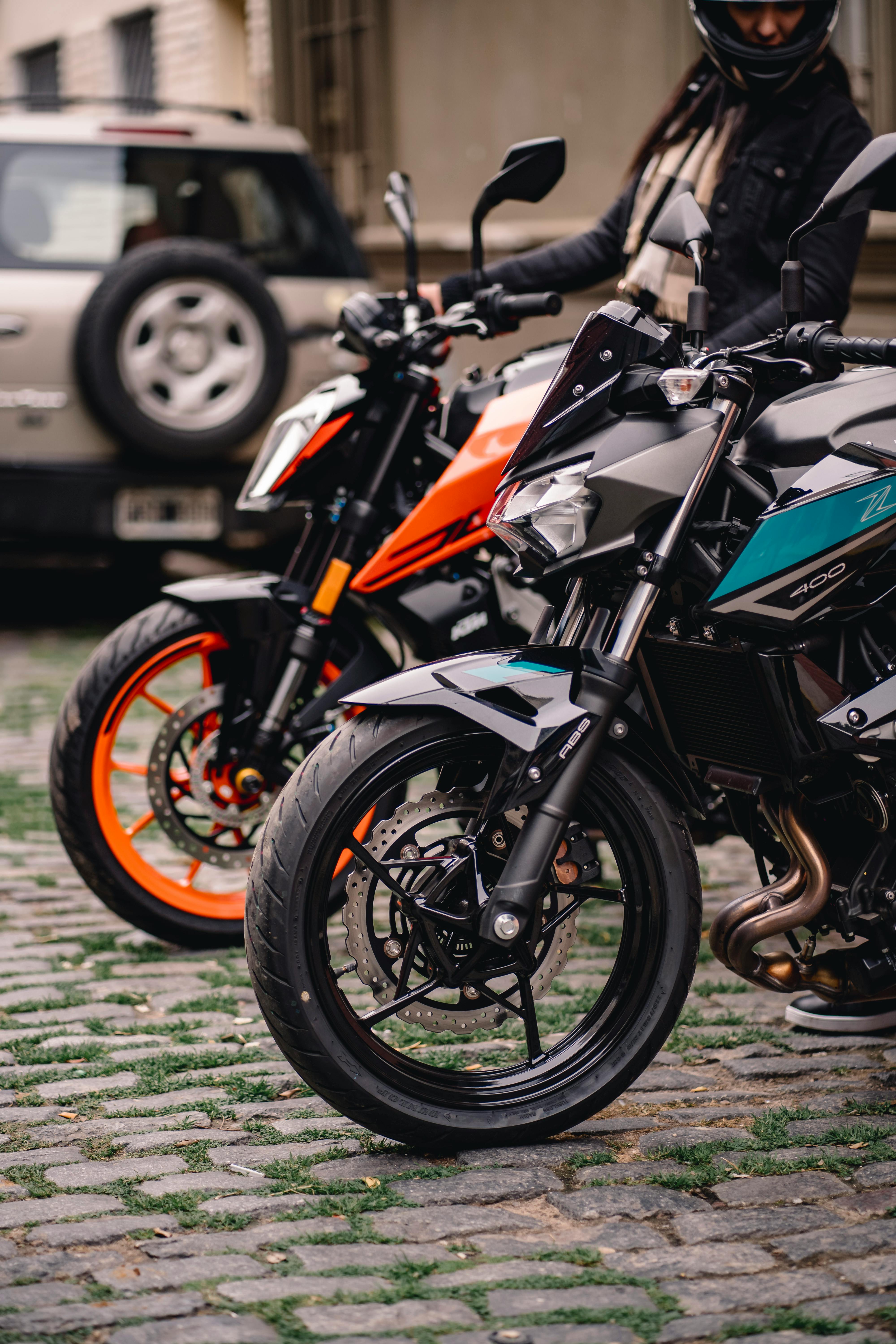 Two motorcycles parked on the side of a road · Free Stock Photo