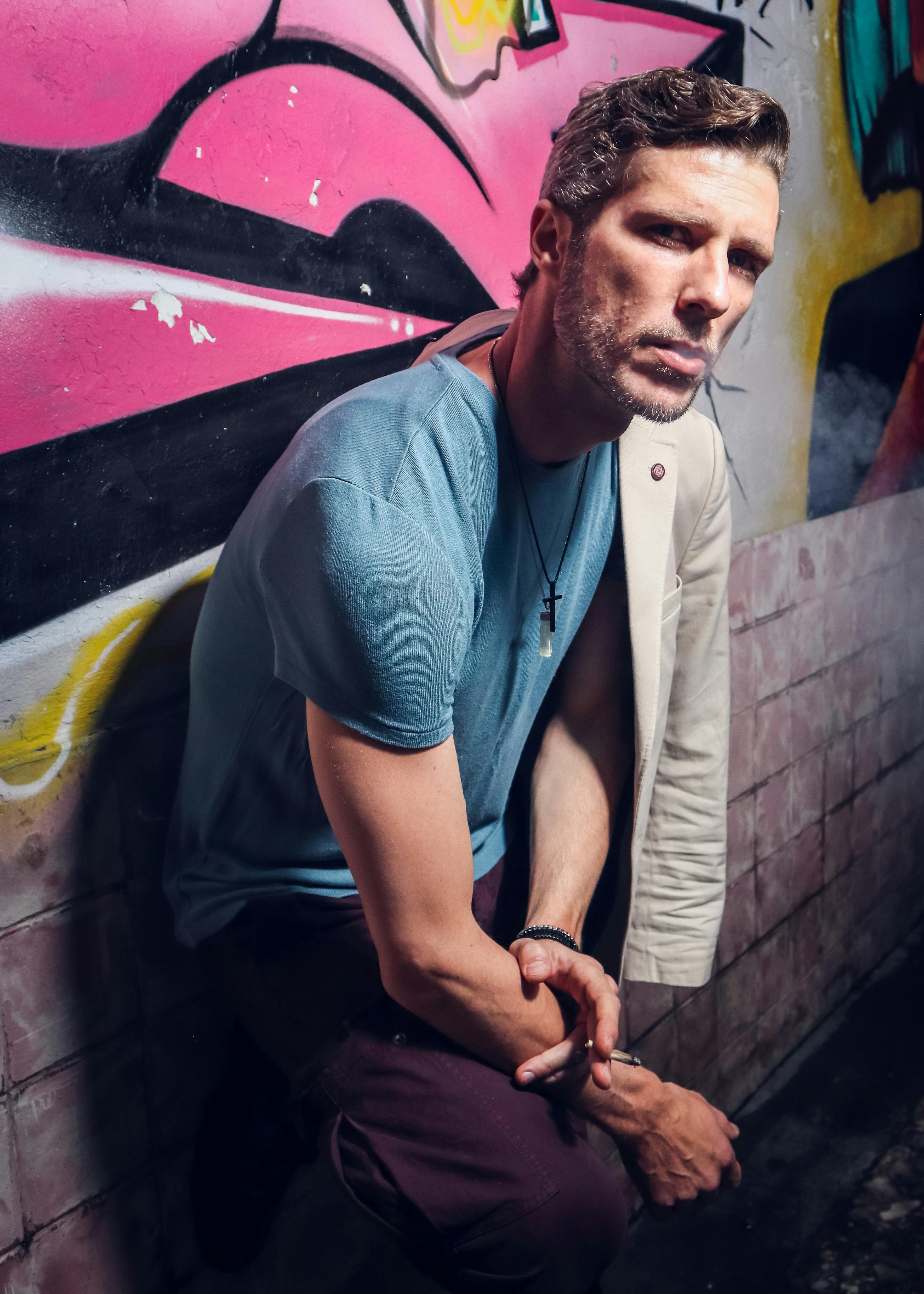 Man Smoking Cigarette by Wall with Graffiti · Free Stock Photo