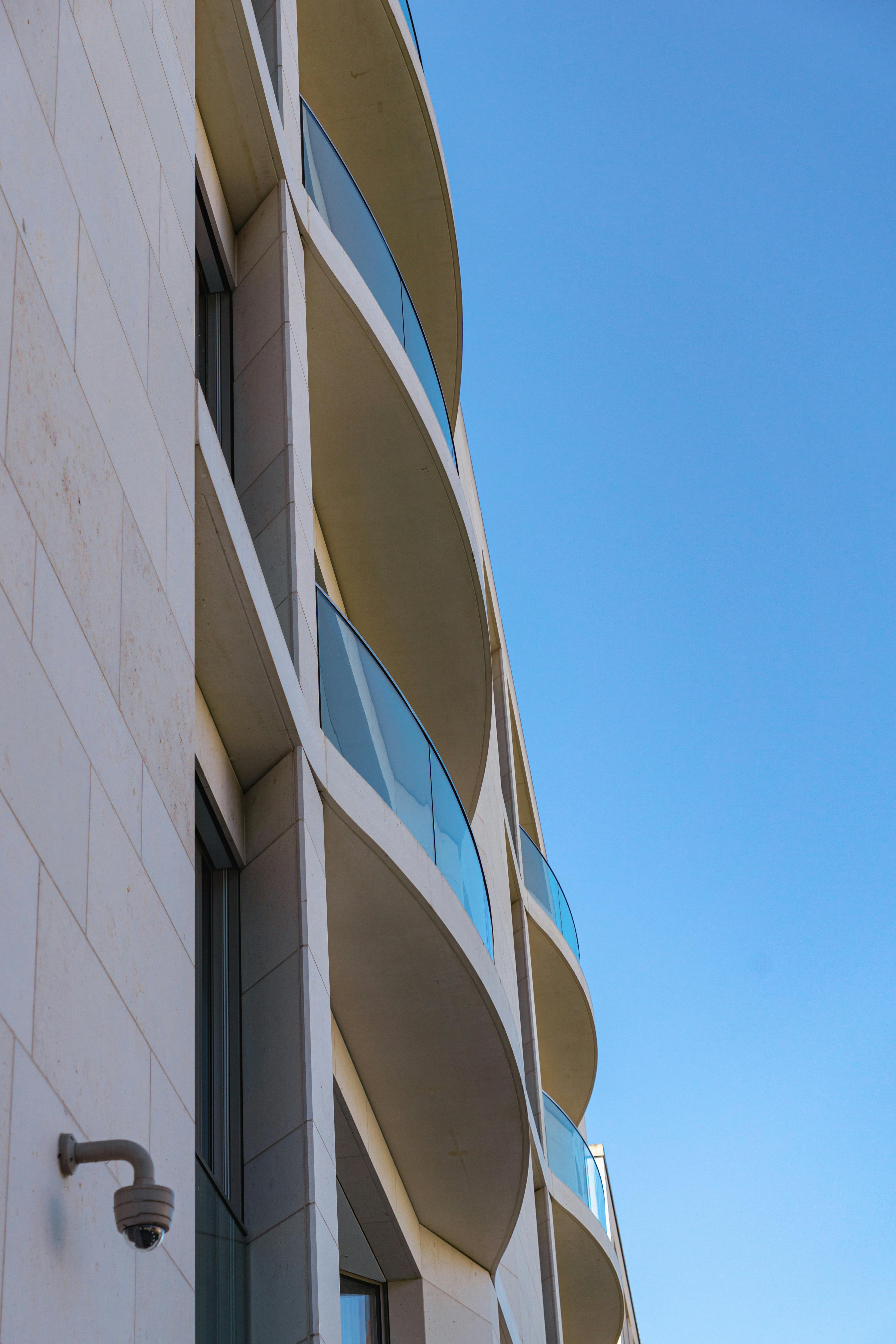 Modern Curved Balcony Design Against Clear Sky · Free Stock Photo