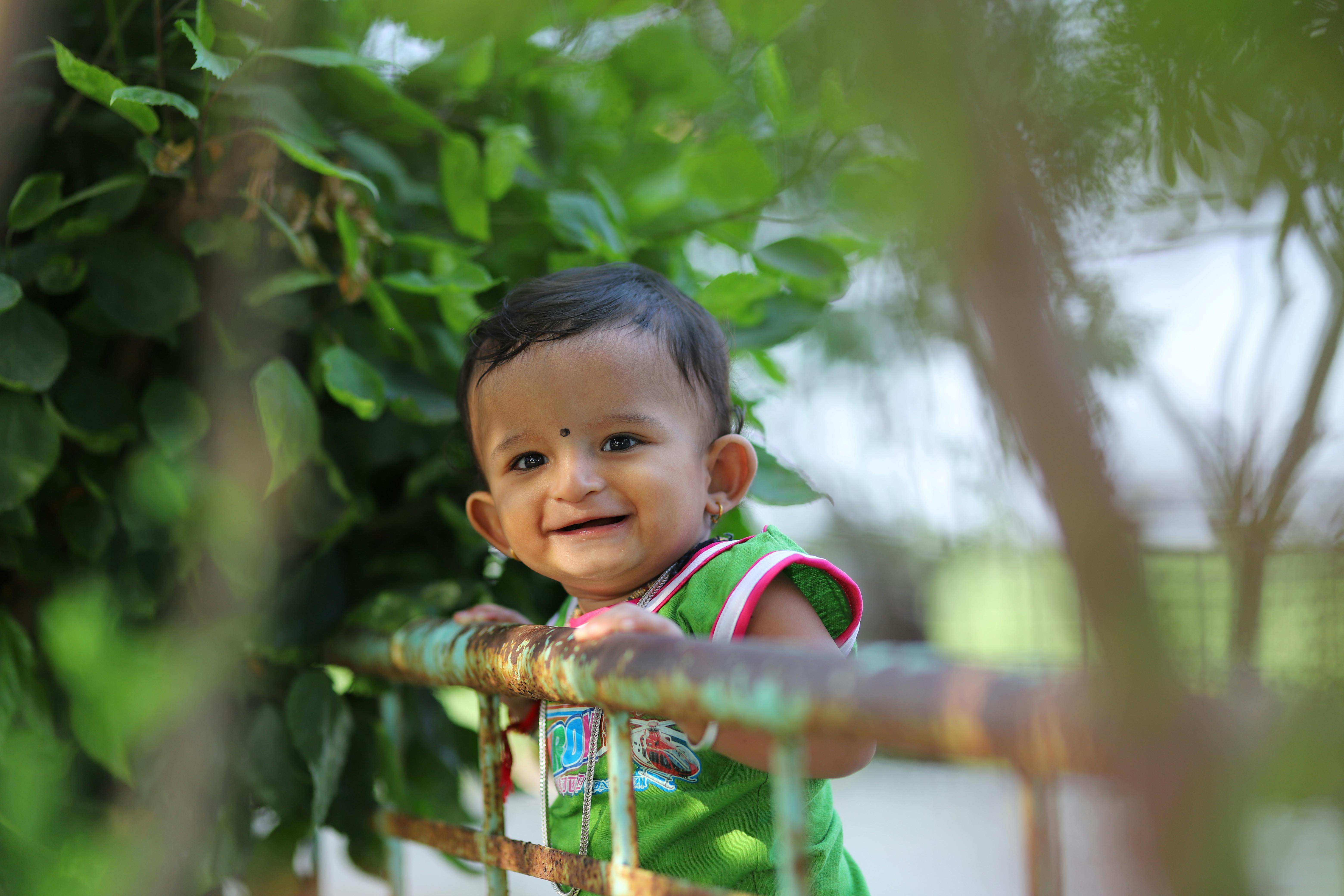 Little Child with a Bind on Forehead at the Fence · Free Stock Photo