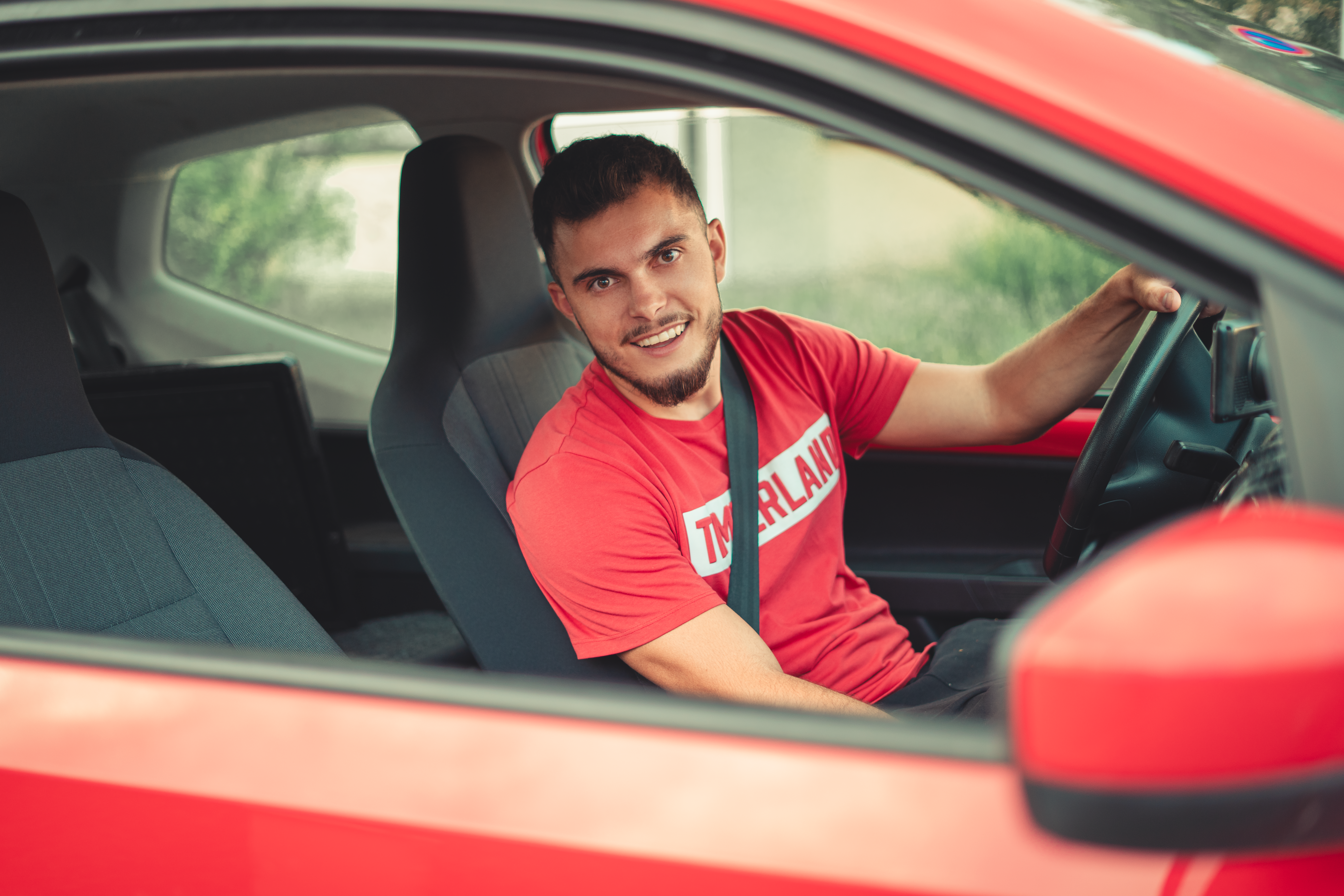 Smiling Man Sitting in Red Car · Free Stock Photo