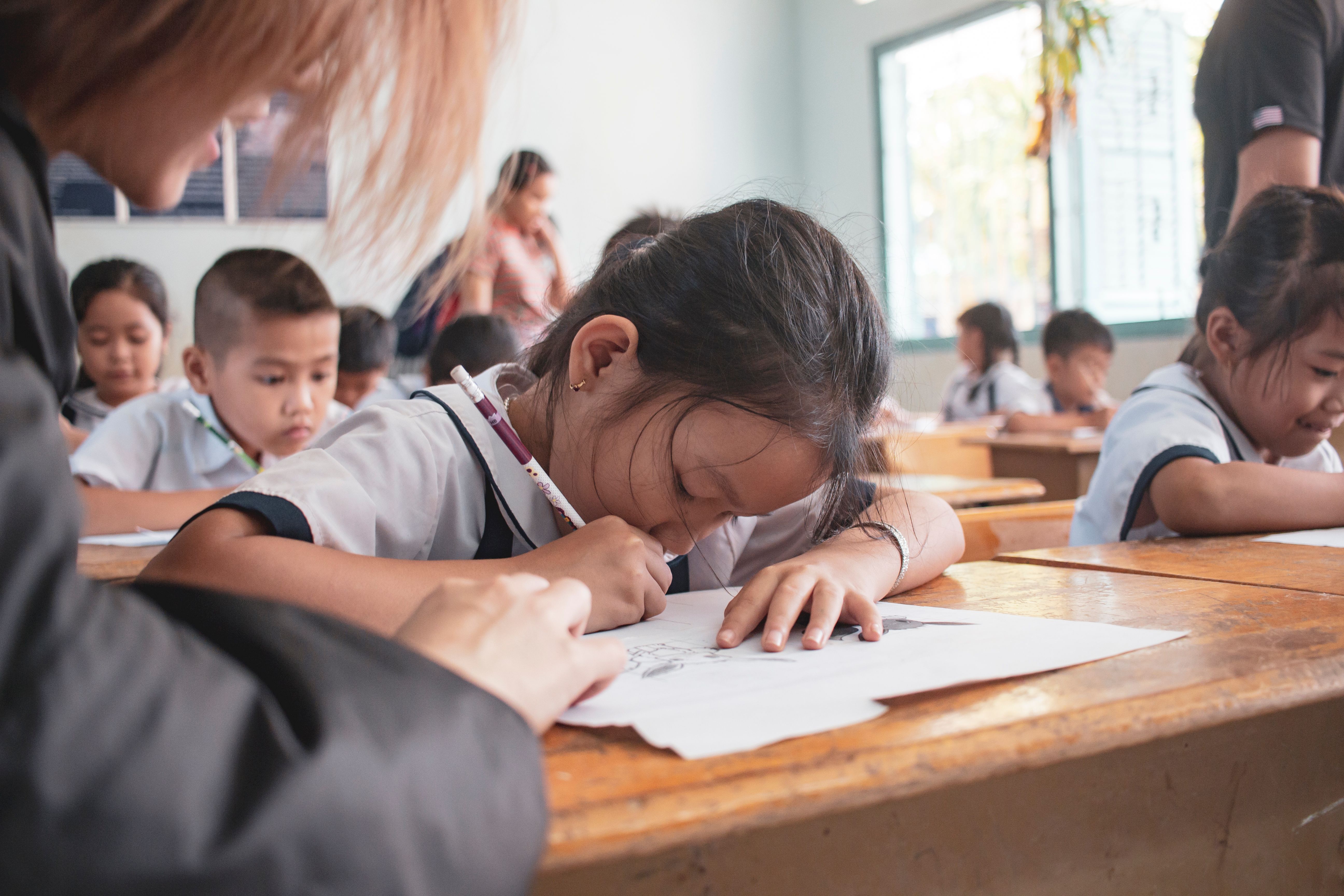 Boy in Brown Shirt Writing on White Paper · Free Stock Photo