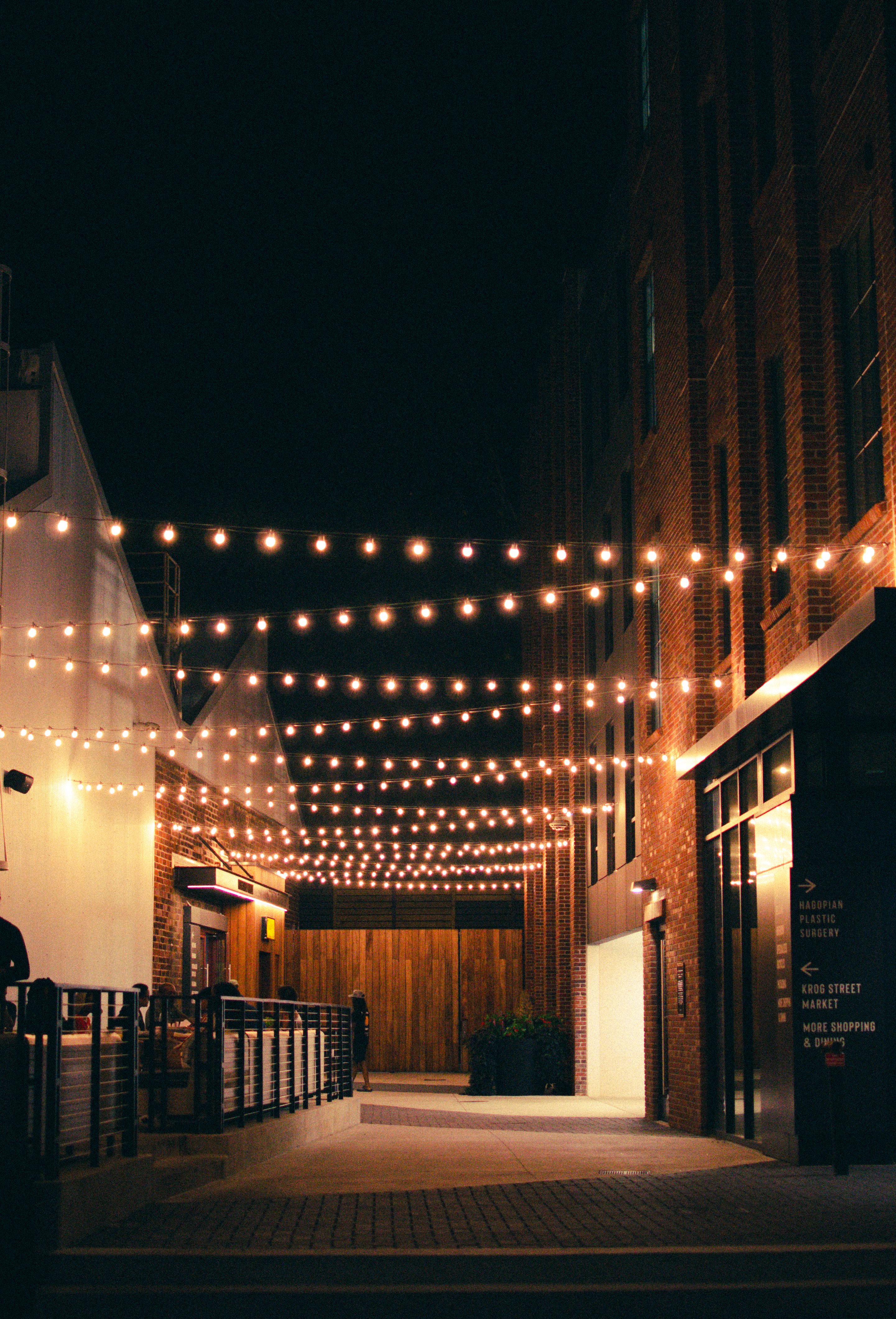 Shining Lamps Hanging between Buildings · Free Stock Photo