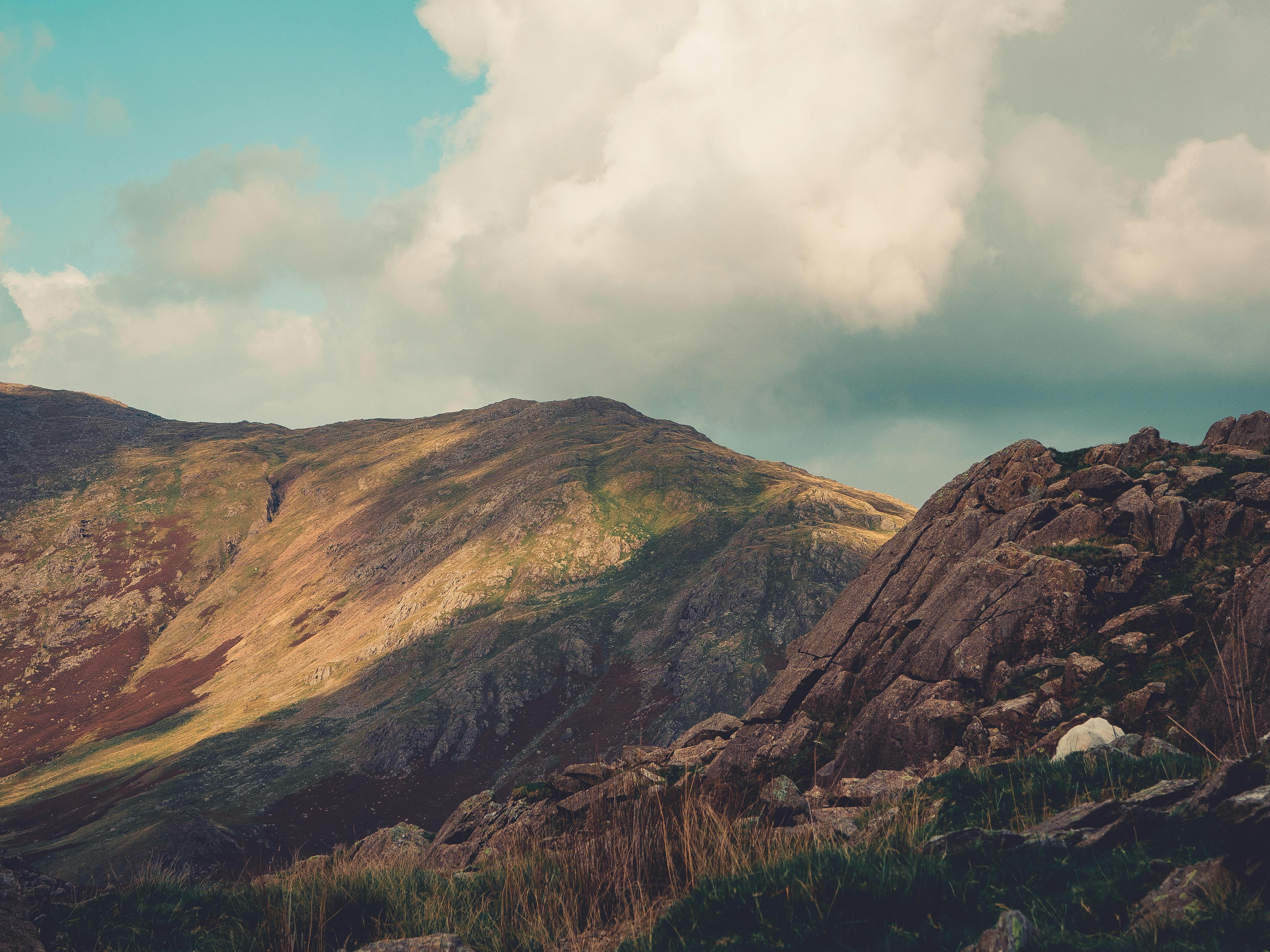 Grey Rocks Cliff Overlooking Marsh during Daytime · Free Stock Photo