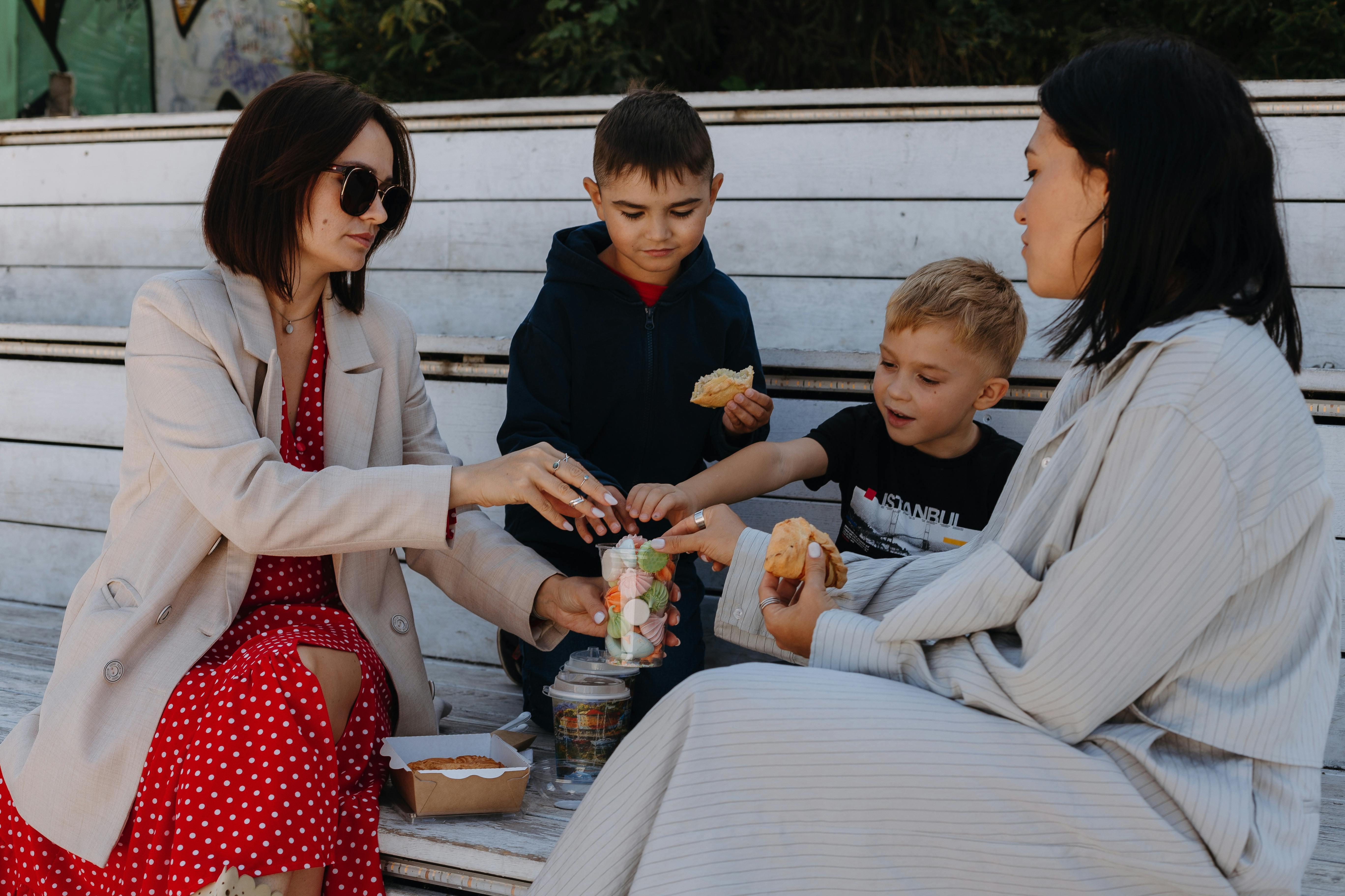 Family Sharing Snacks on a Bench · Free Stock Photo