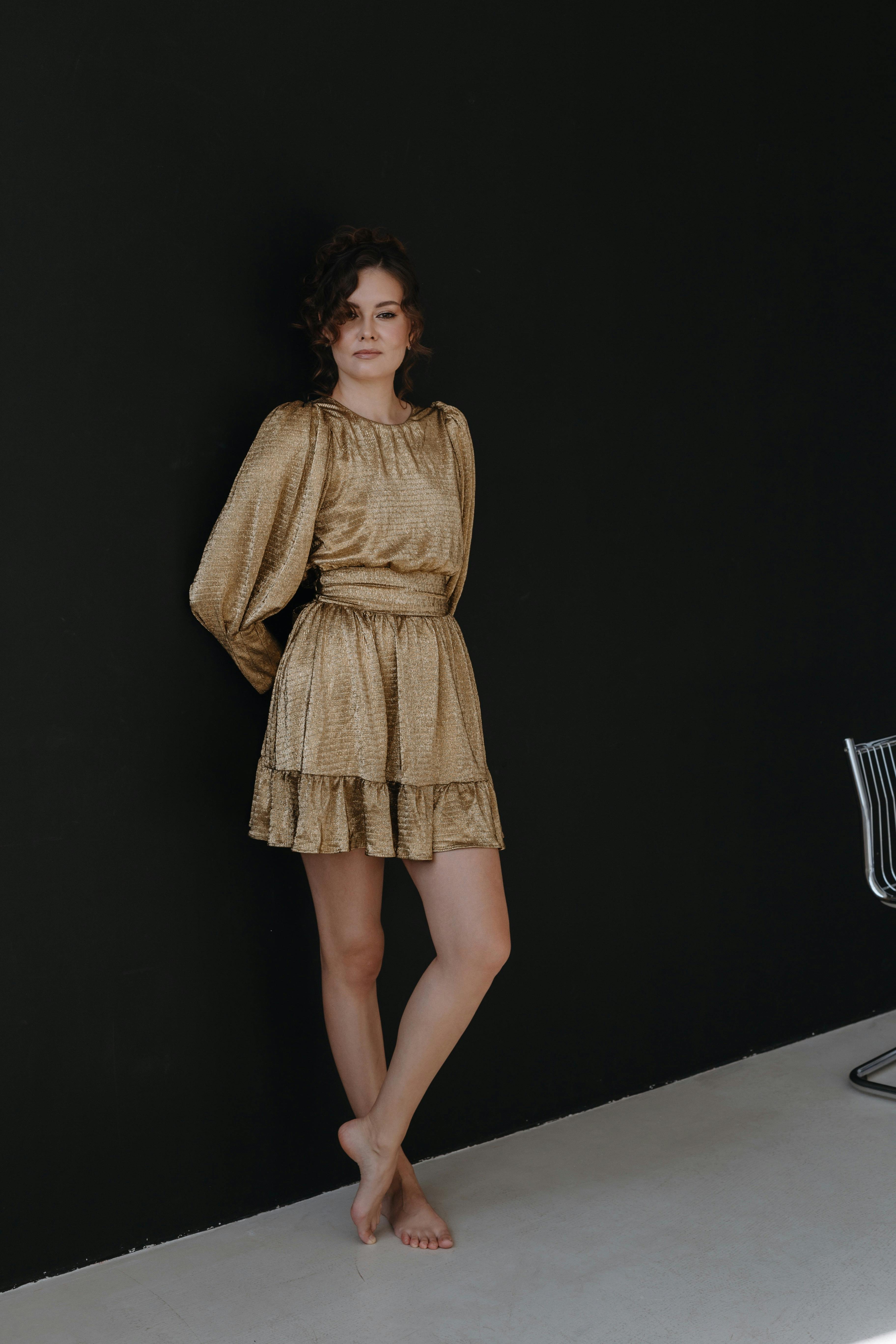 Brunette Woman in Golden Mini Dress Posing against Black Wall · Free ...