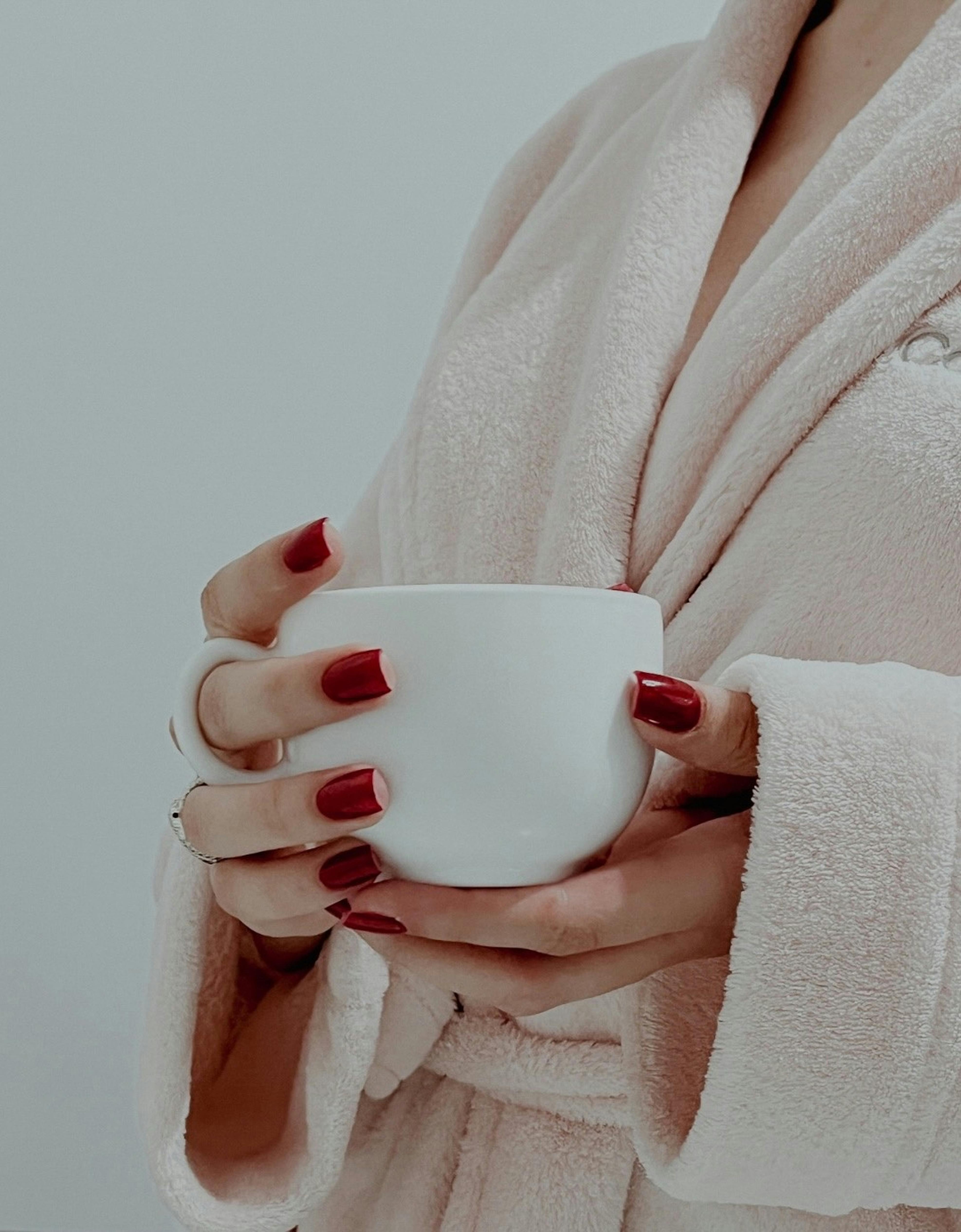 Hands of a Woman Wearing a Bathrobe Holding a Mug · Free Stock Photo