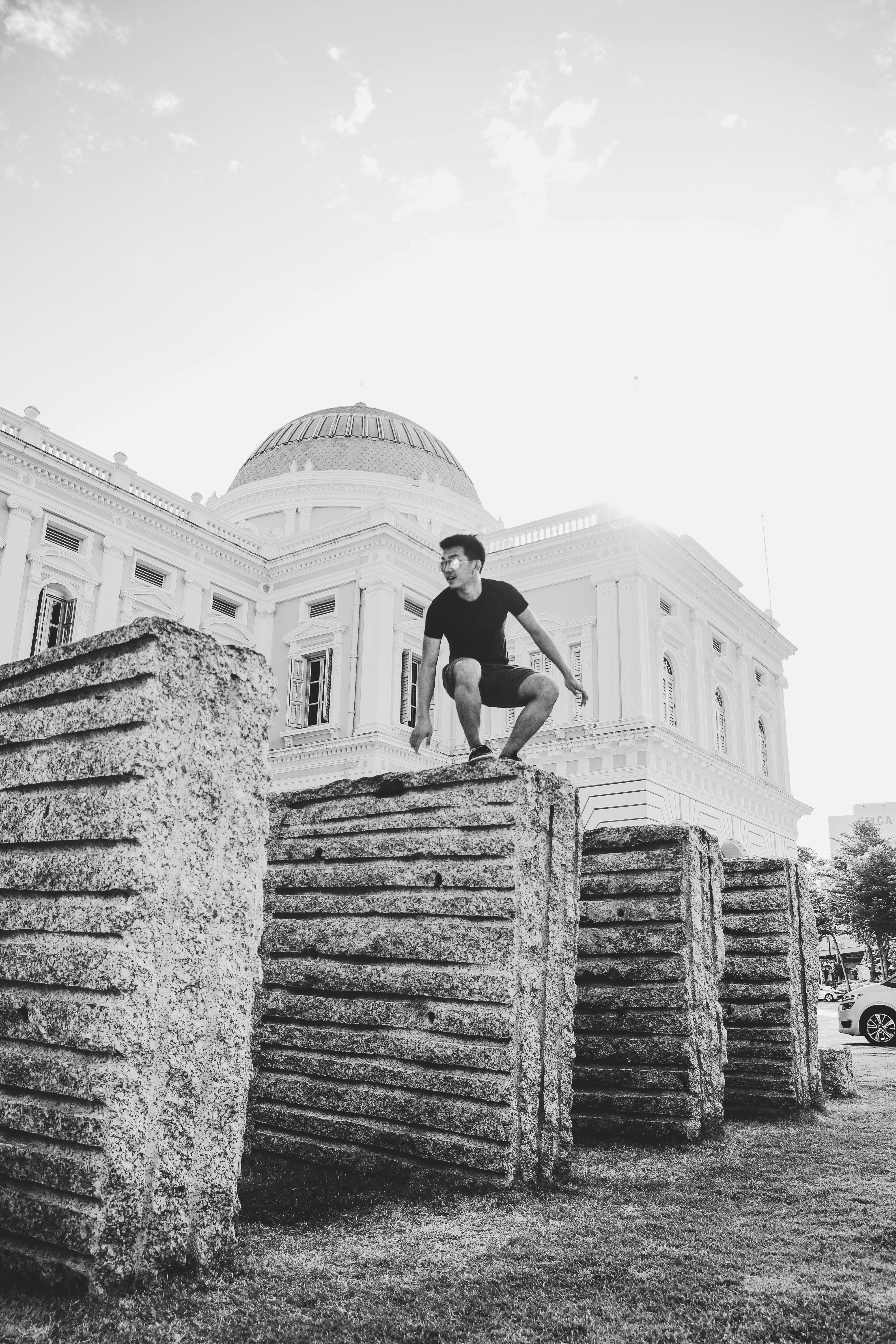 Young Man Jumping Off the High Bricks by a Big Cathedral in Black and ...