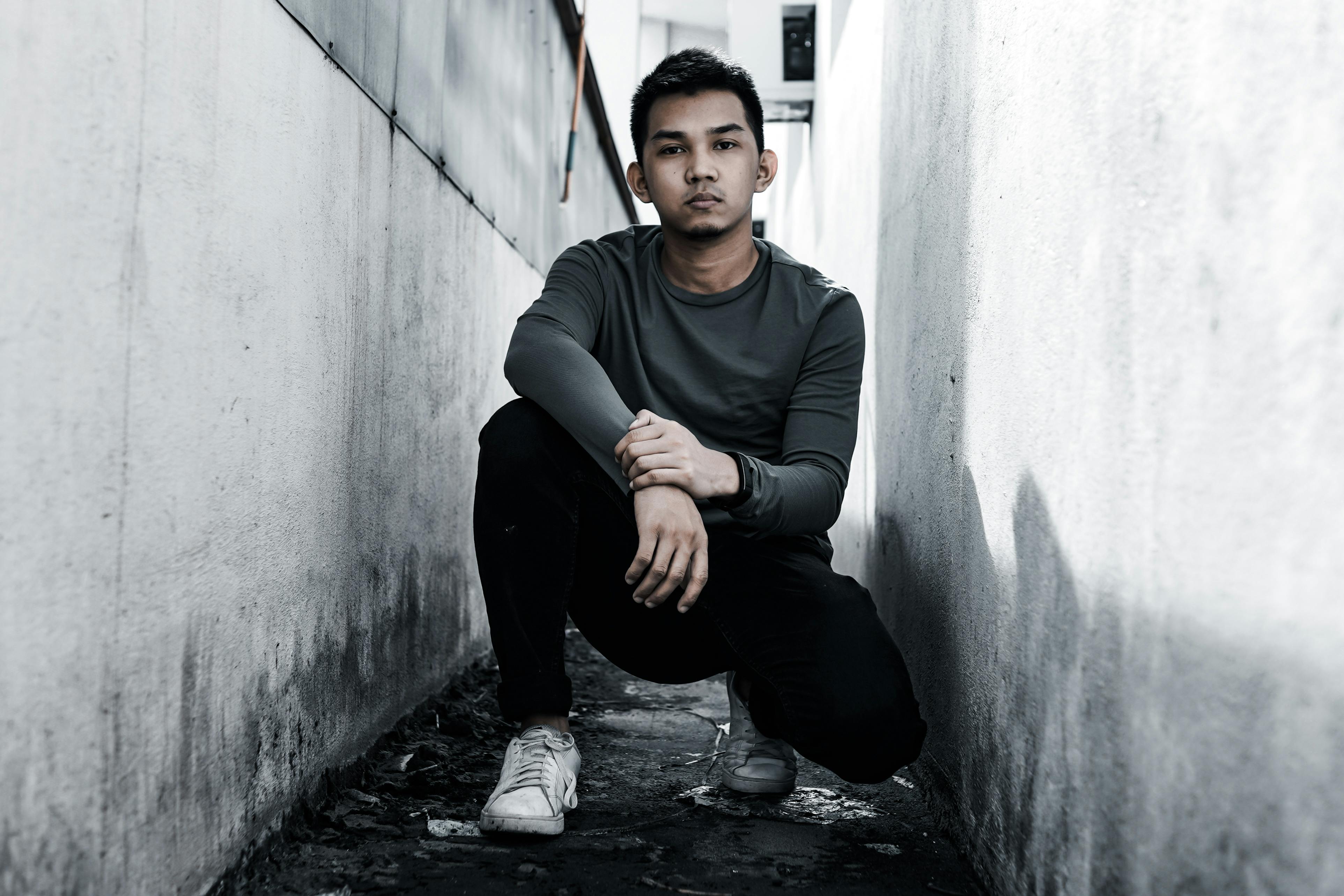 Man Crouching in an Alley · Free Stock Photo