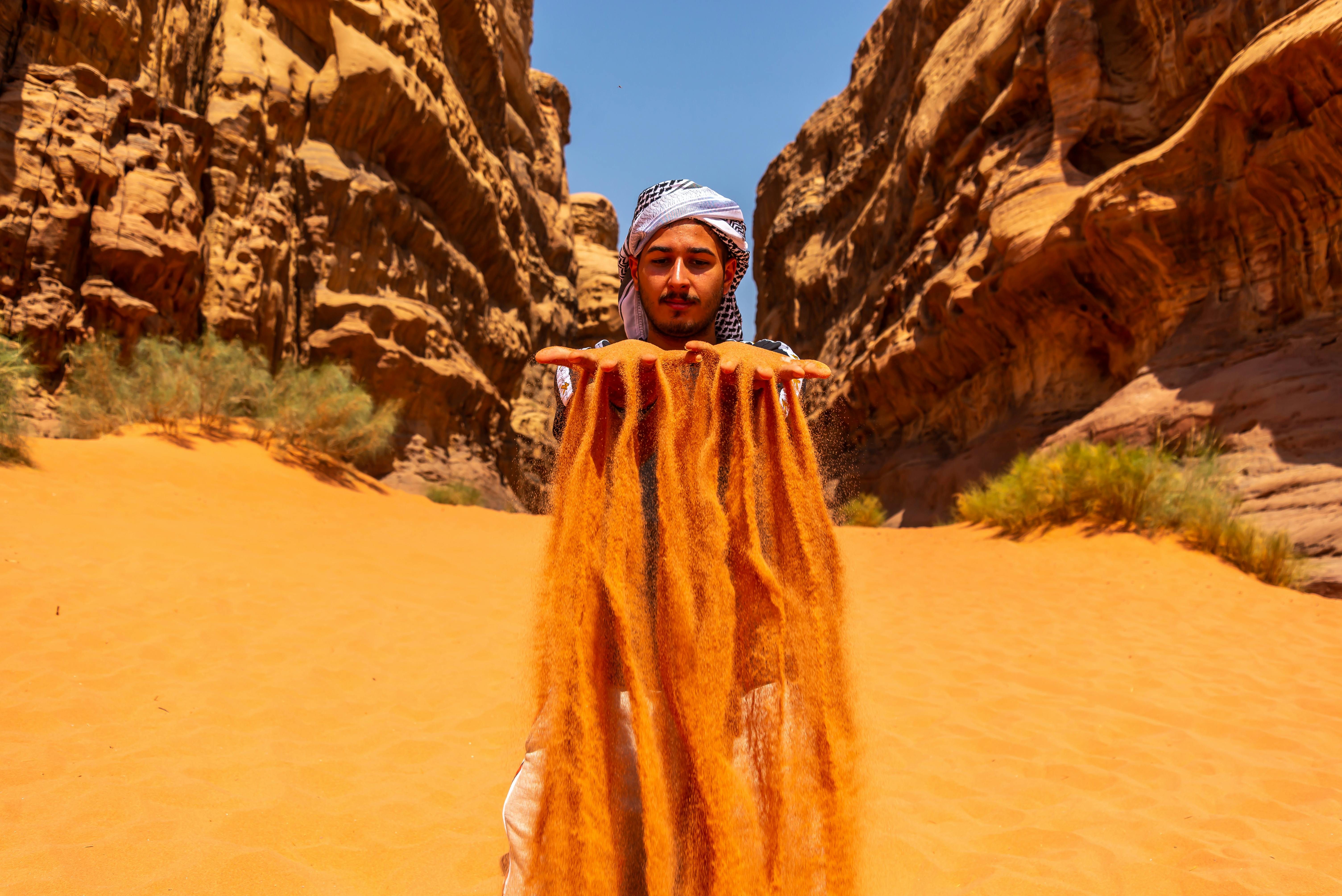 Man in a Turban with Sand Falling from His Outstretched Hands · Free ...