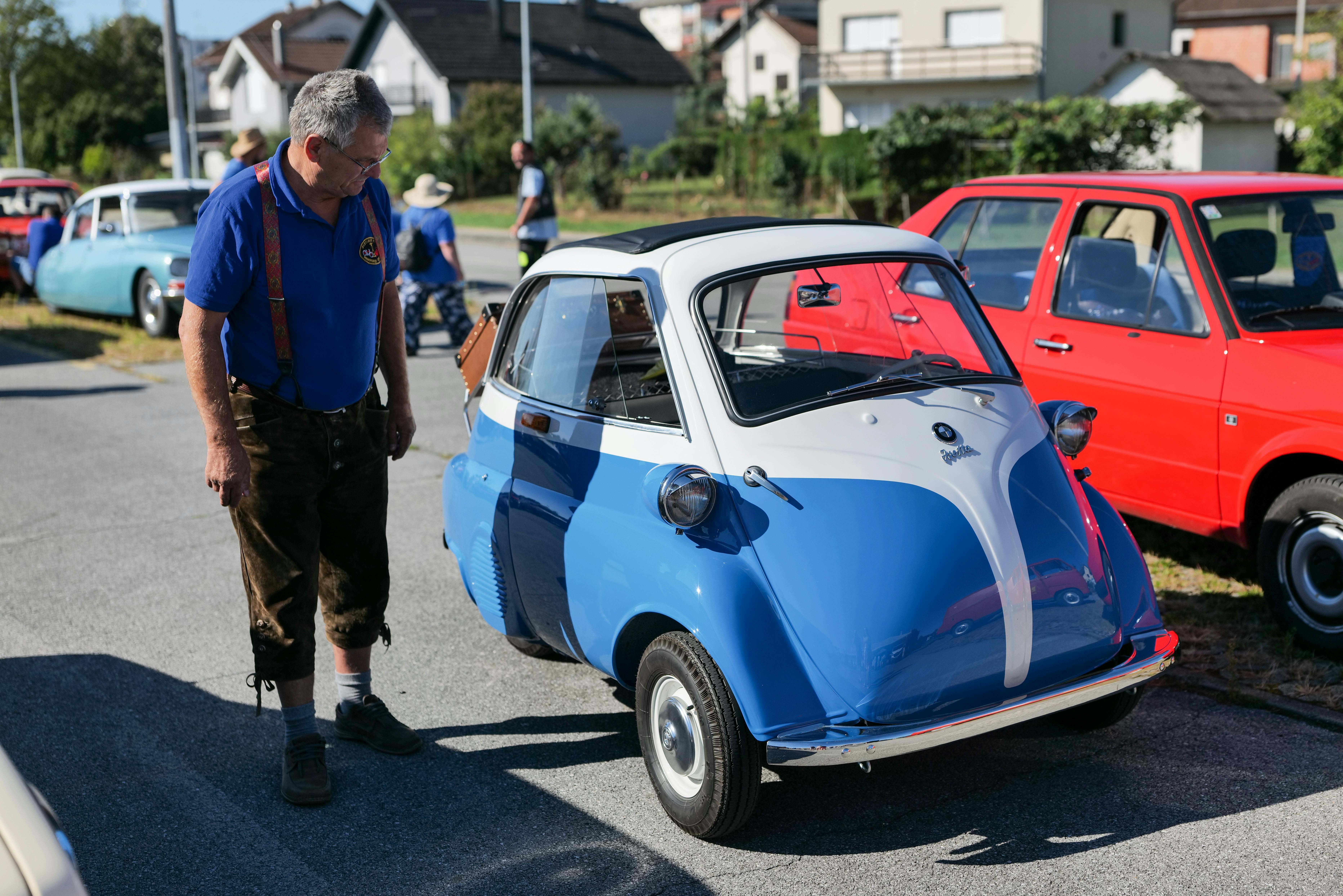 Man Looking at a Vintage Microcar · Free Stock Photo
